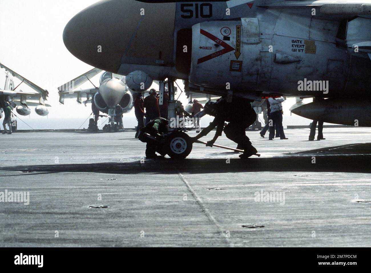 Flight deck crewmen prepare an A-6 Intruder aircraft for flight aboard ...