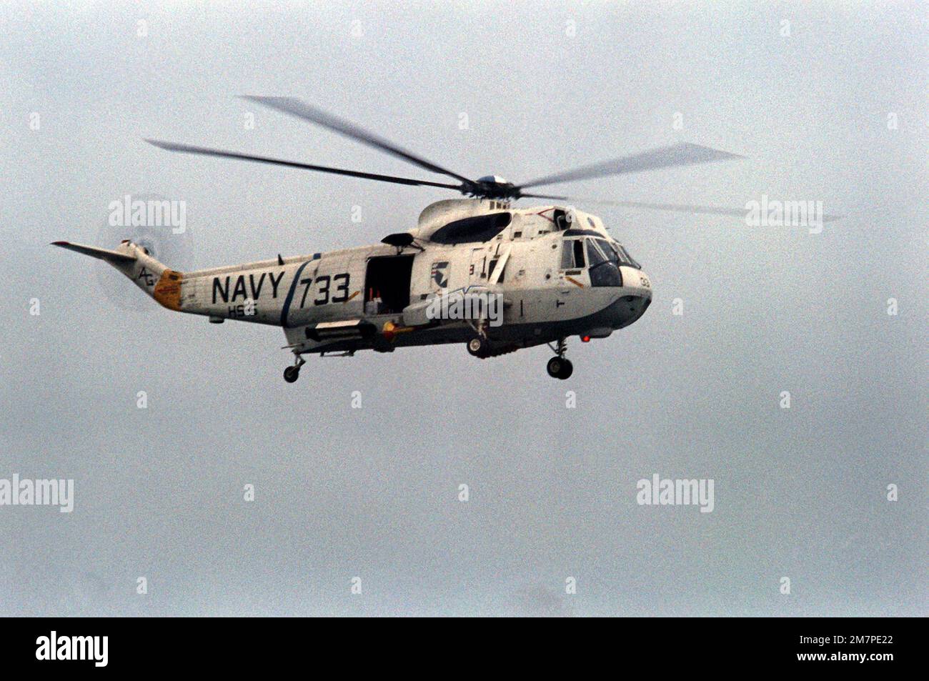 An SH-3 Sea King helicopter approaches for a landing on the flight deck ...