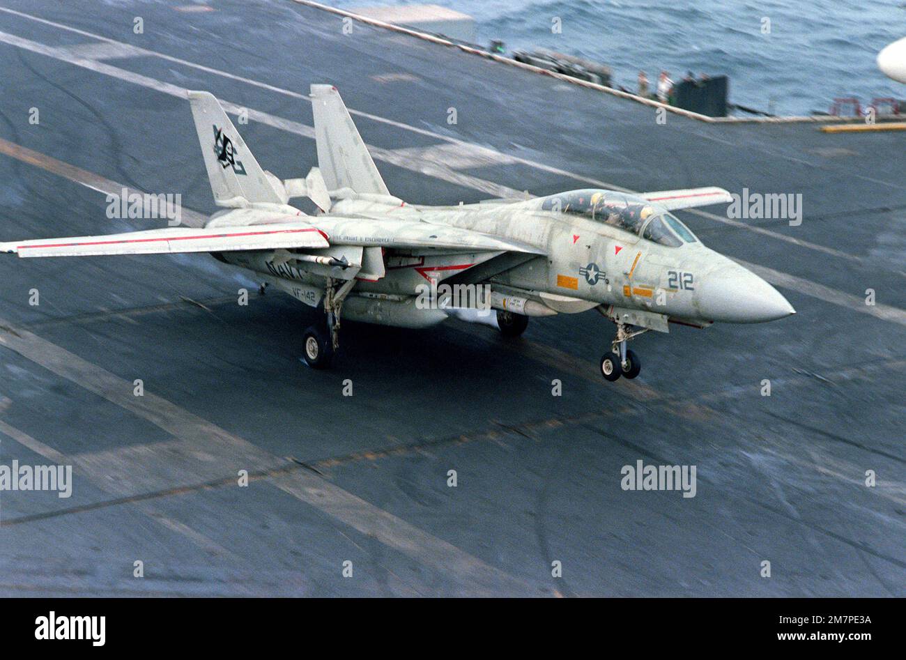 An F-14 Tomcat aircraft makes an arrested landing on the flight deck of ...