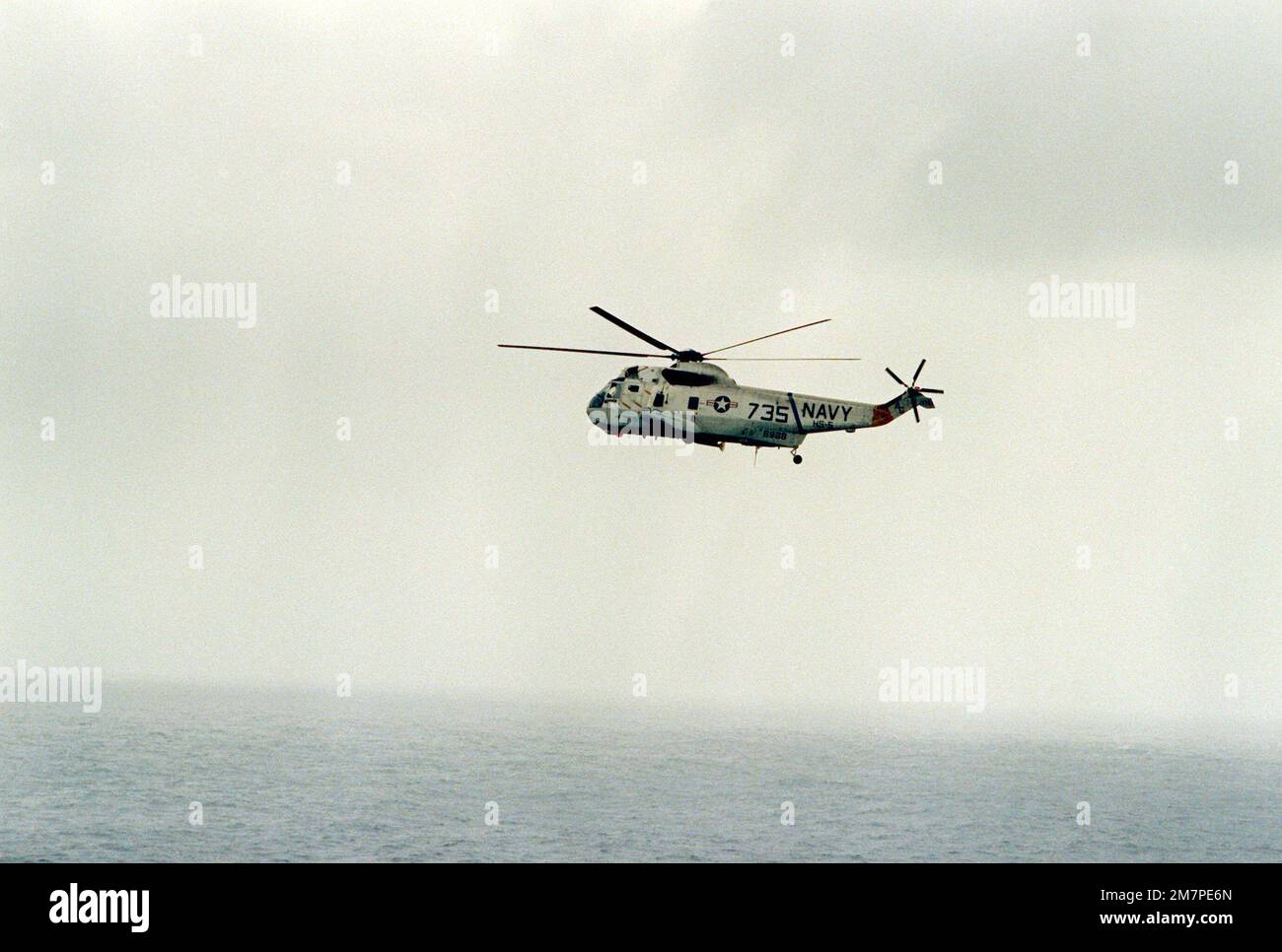 An SH-3 Sea King helicopter approaches for a landing on the flight deck ...