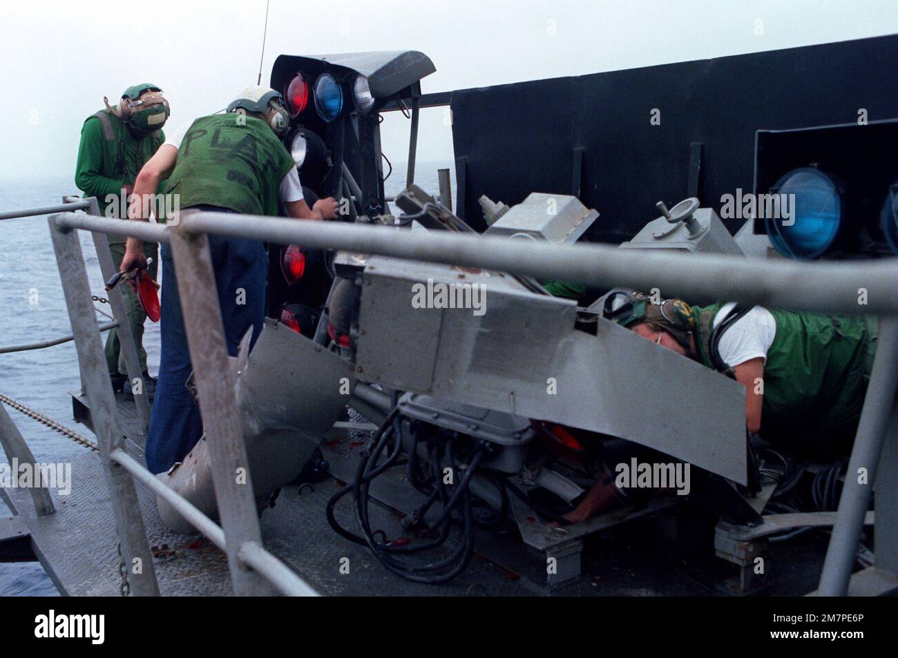 Crew members replace a lens in the deck edge assembly of the optical ...