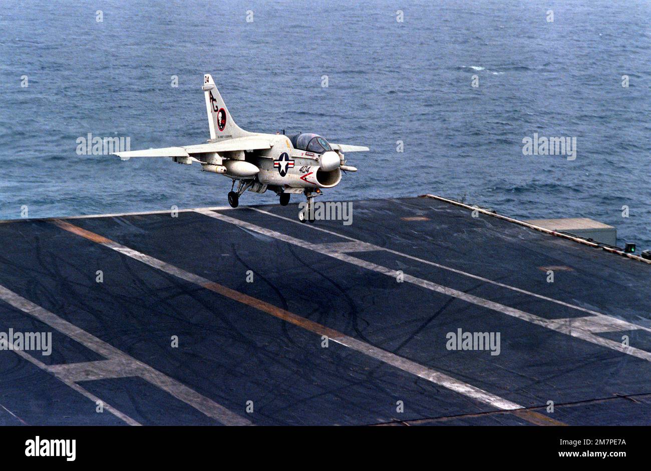 An A-7E Corsair II aircraft prepares to touch down on the flight deck ...