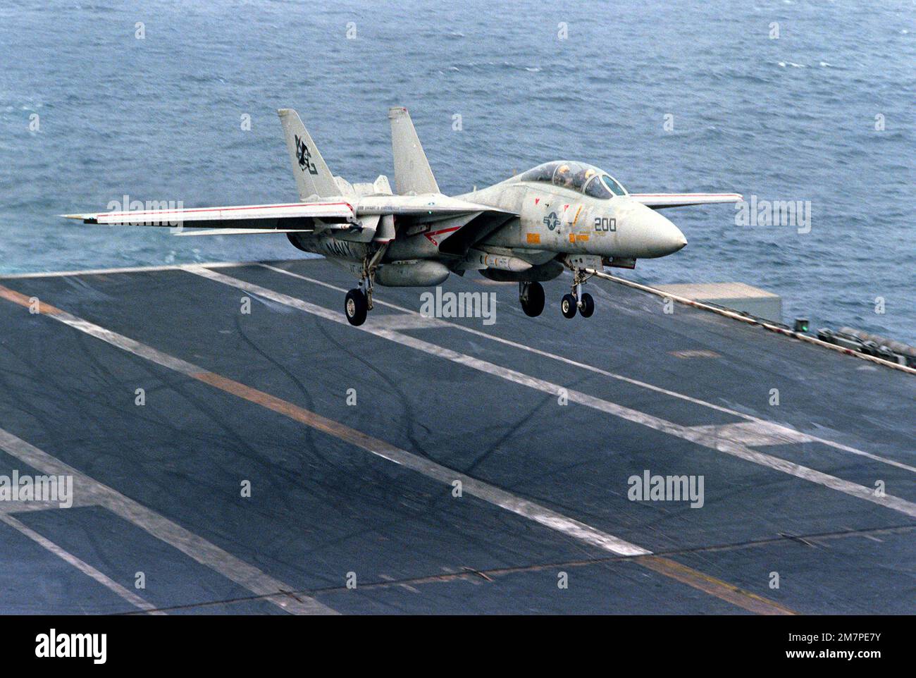 An F-14 Tomcat aircraft makes an arrested landing on the flight deck of ...