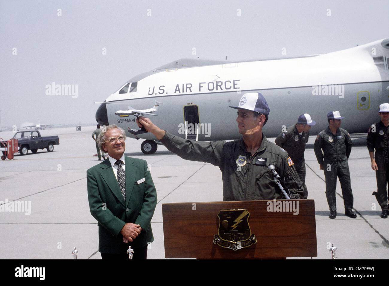 COL. Watts, commander, 63rd Military Airlift Wing, holds a model of a C ...