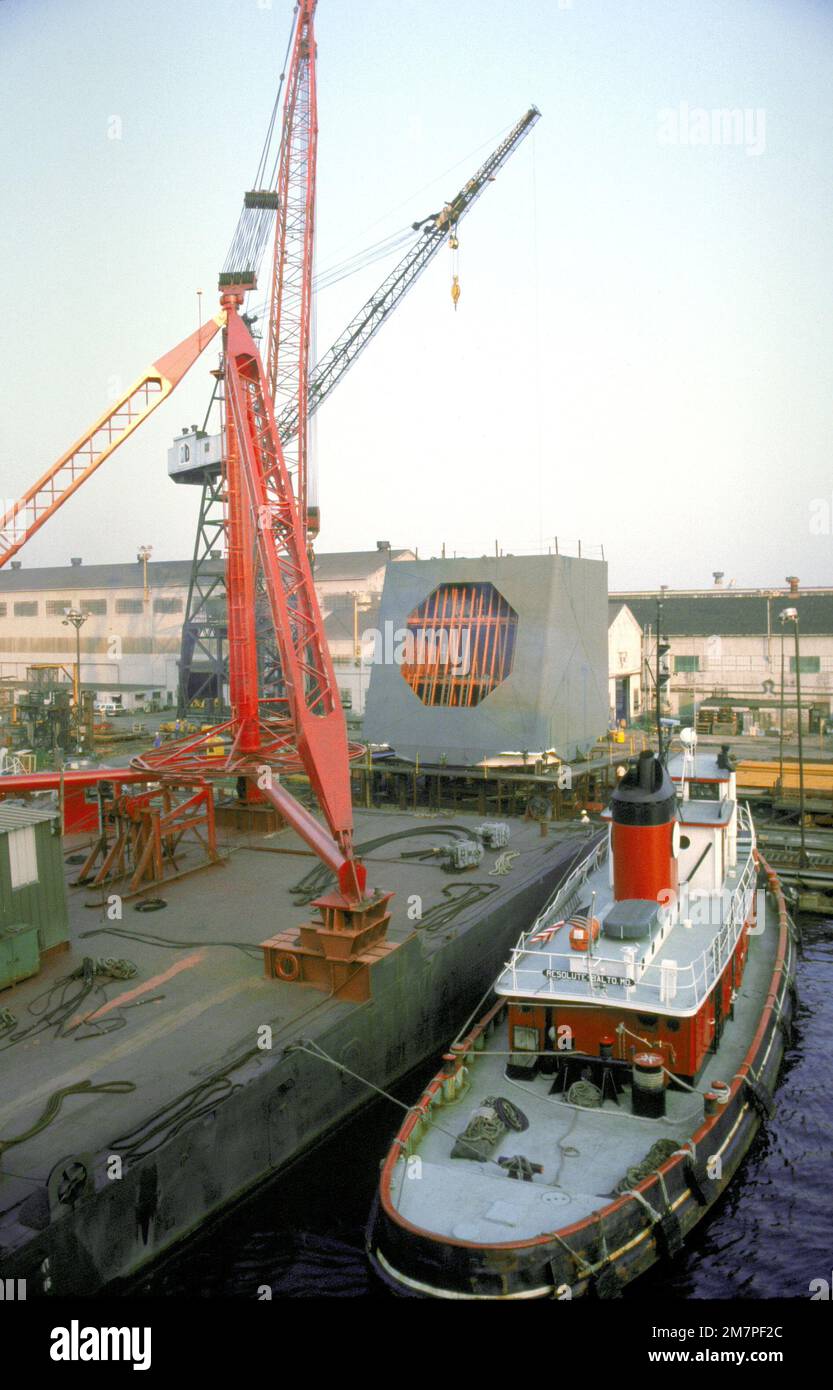 A lift barge/crane, being propelled by a tugboat on each side, moves ...