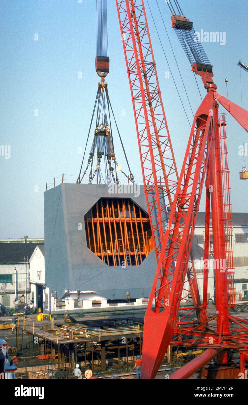 A lift barge/crane, being propelled by a tugboat on each side, lifts ...