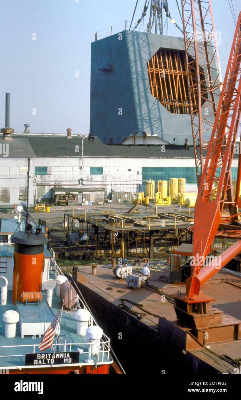 A lift barge/crane, being propelled by a tugboat on each side, lifts ...