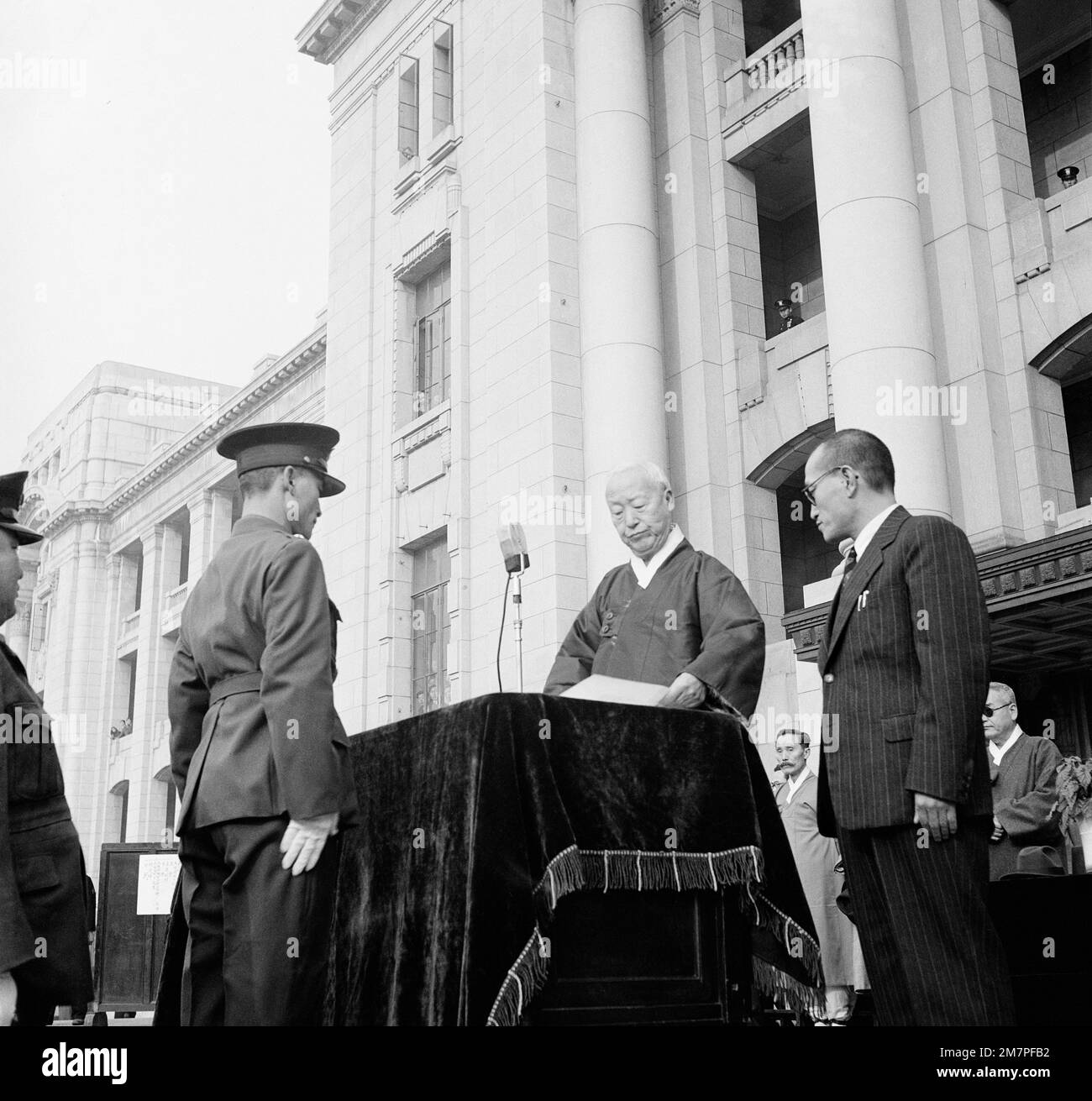 Korean President Syngman Rhee, second from right, reads the commission ...