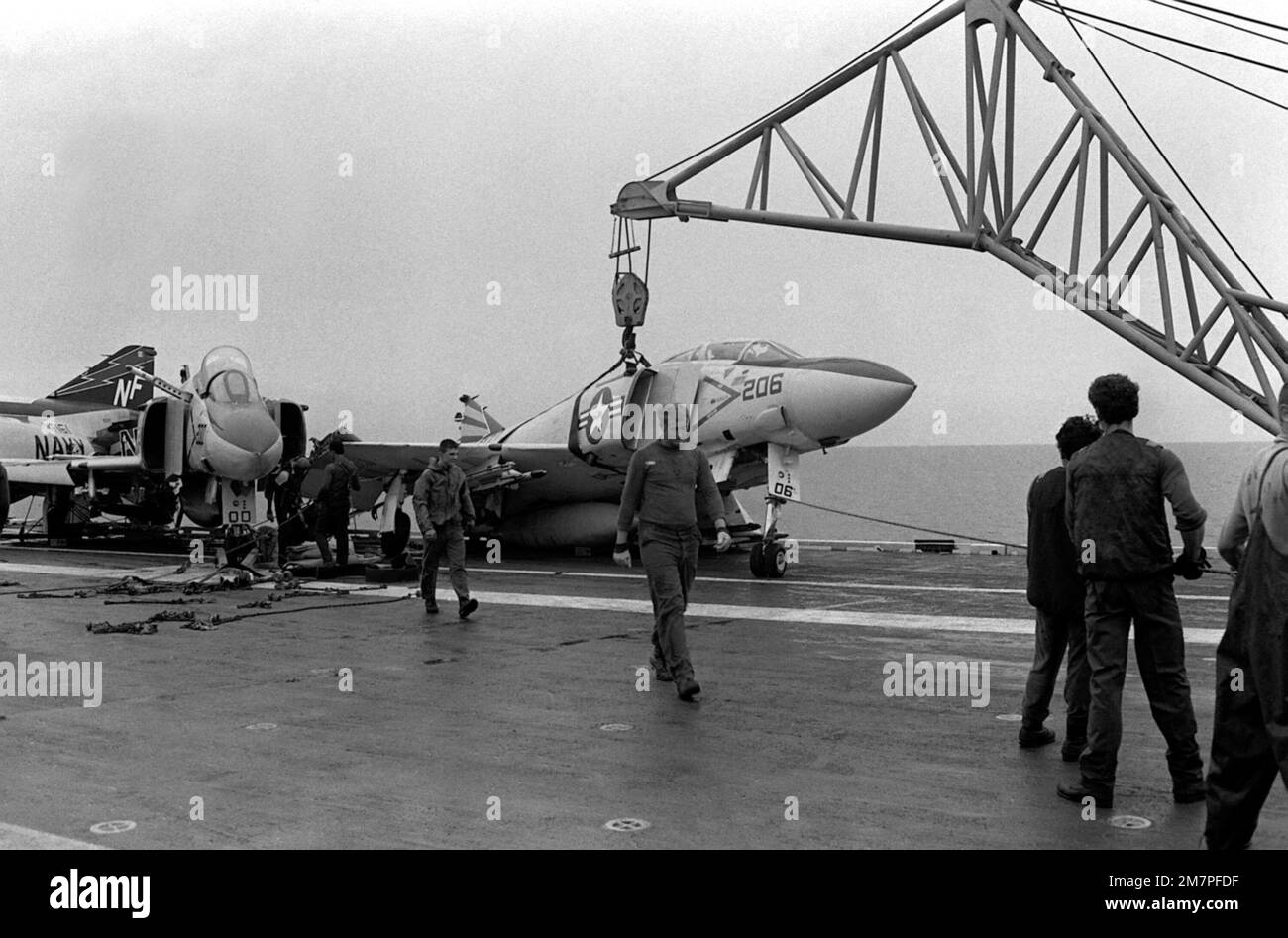A crane is used to lift an F-4 Phantom II aircraft away from the port ...