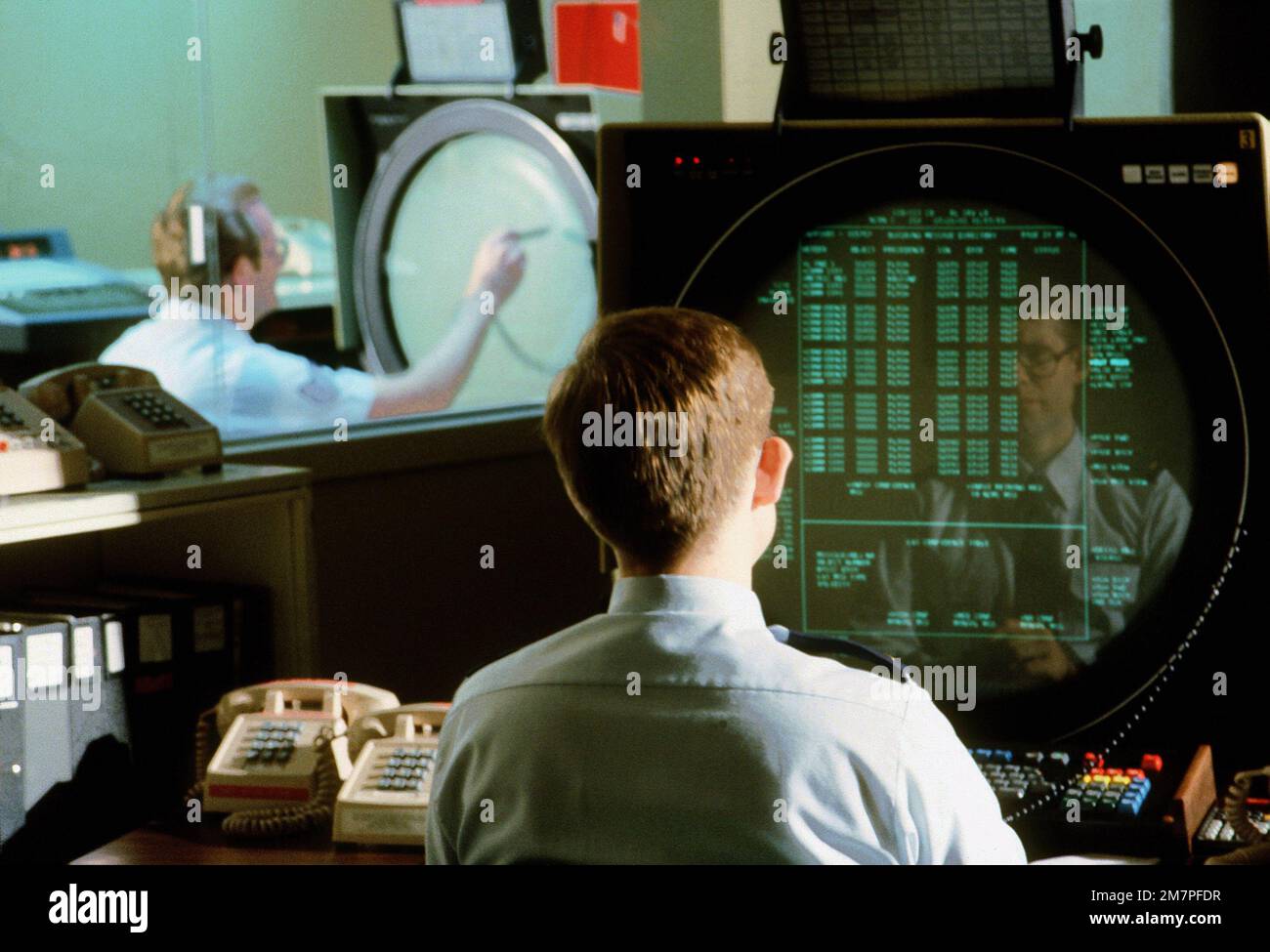 Back view of controllers at work in the command section of the Pave ...