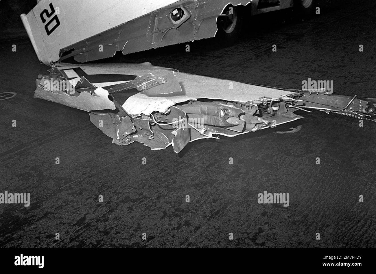 The severed wing tip of an F-4 Phantom II aircraft rests on the flight ...