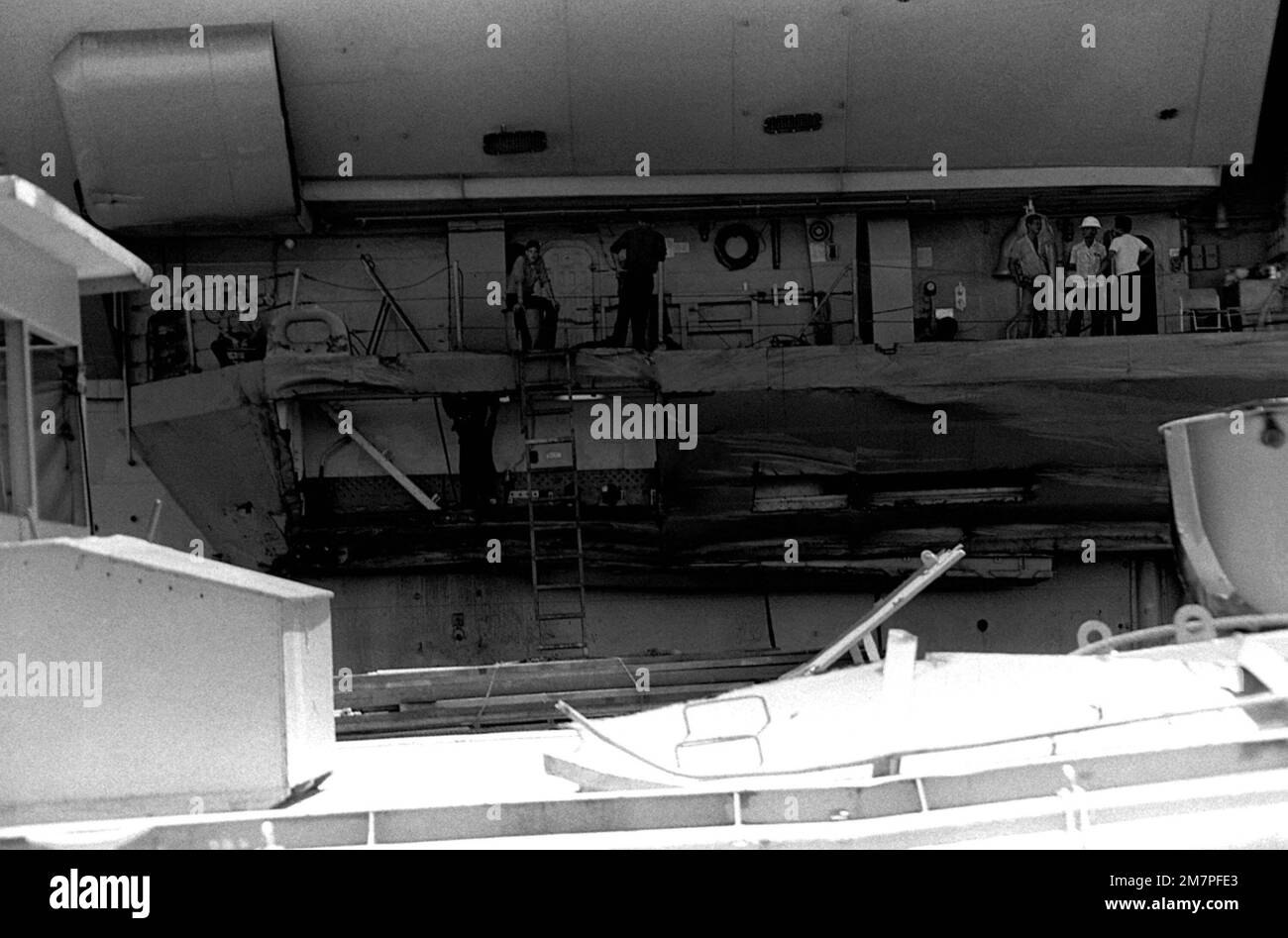A view of damage caused to the port side of the aircraft carrier USS ...