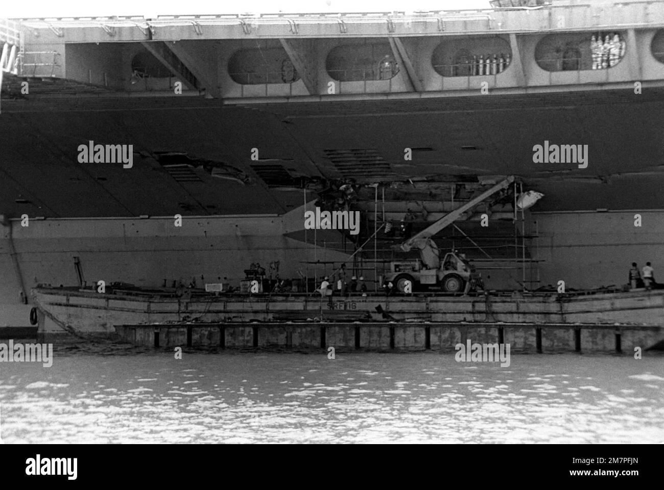 A view of damage caused to the port amidships section of the aircraft ...