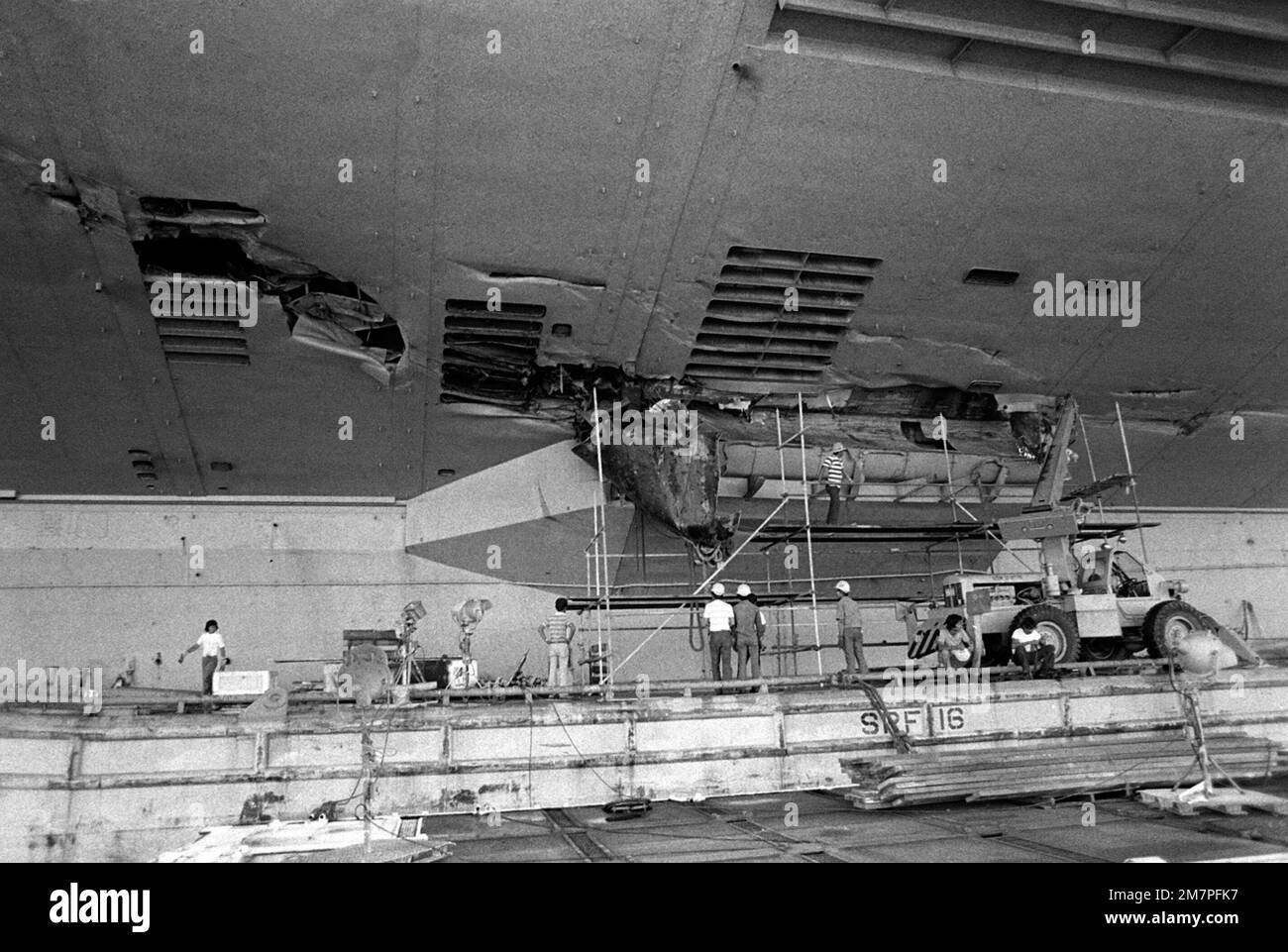 A view of damage caused to the port amidships section of the aircraft ...