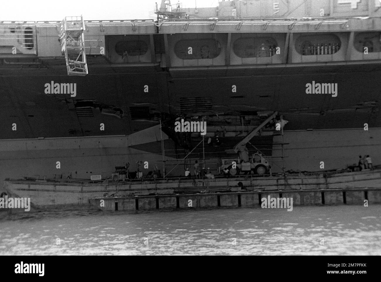 A view of damage caused to the port amidships section of the aircraft ...