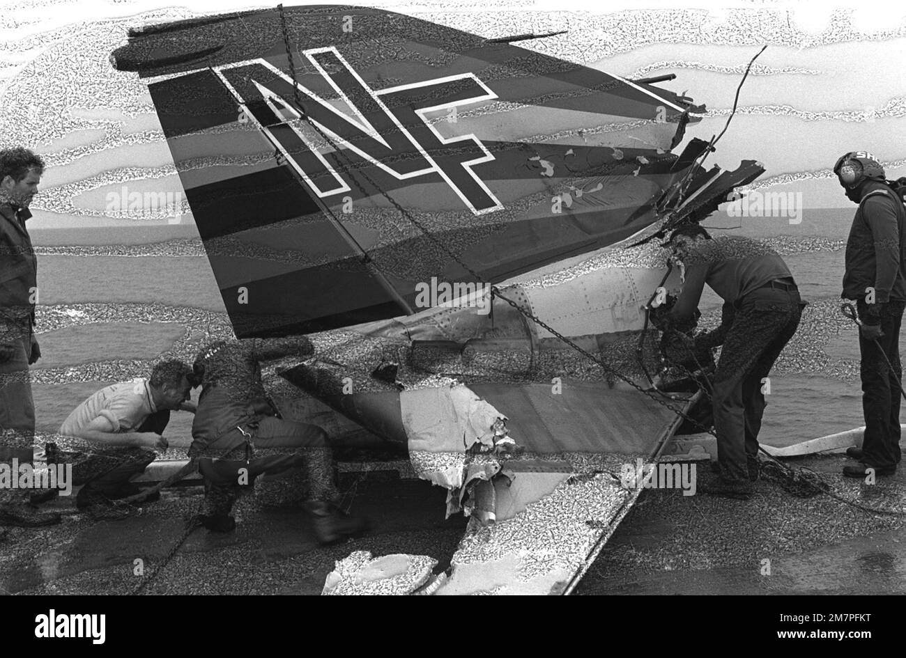 Crewmen prepare to remove the severed tail section of an F-4 Phantom II ...