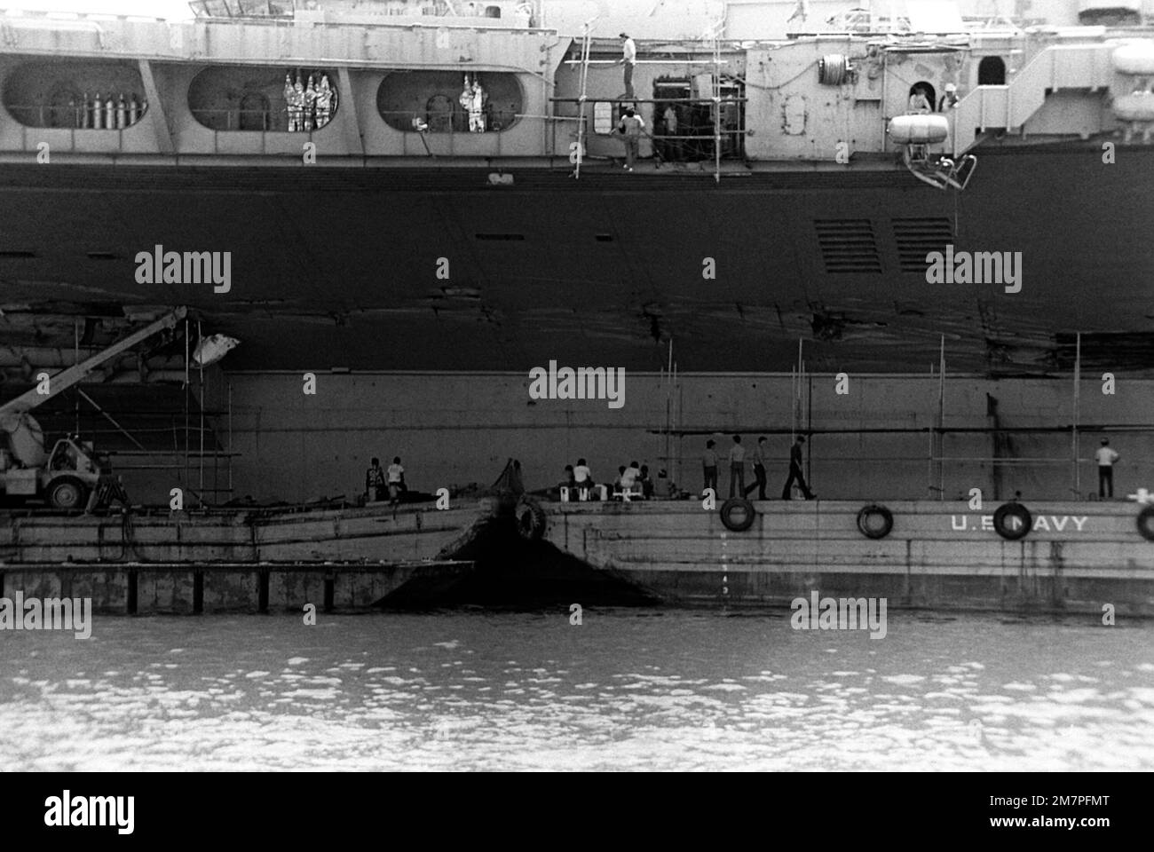 A view of damage caused to the port side amidships section of the ...