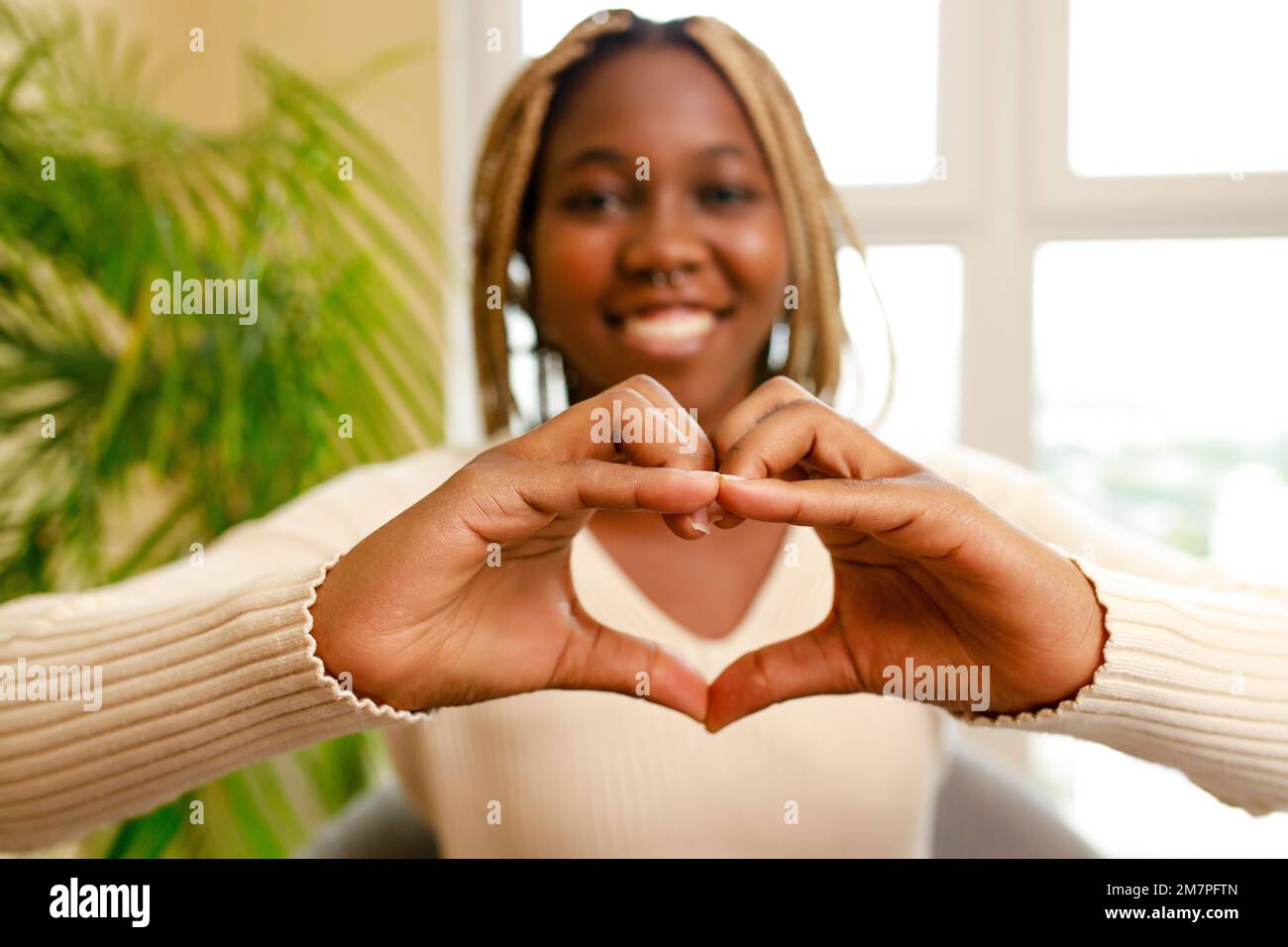 hispanic woman showing love with hands in heart shape expressing healthy and marriage symbol ...