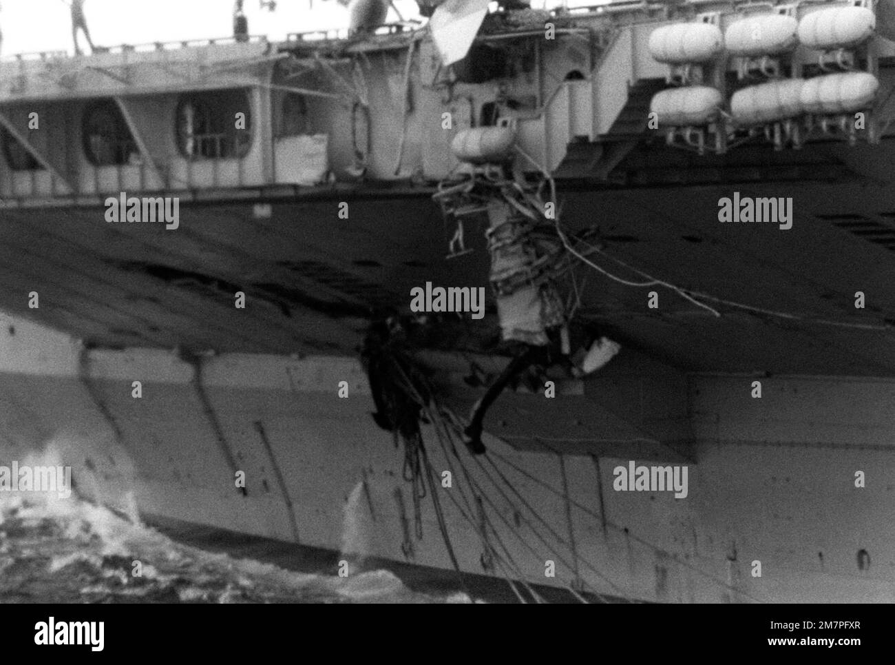 A view of damage caused to the port amidships section of the aircraft ...