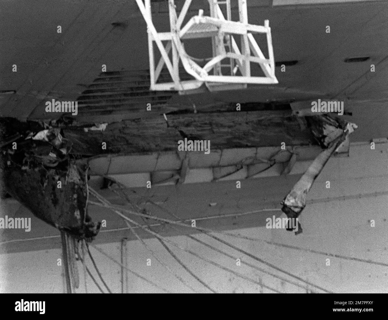 A view of damage caused to the port amidships section of the aircraft ...