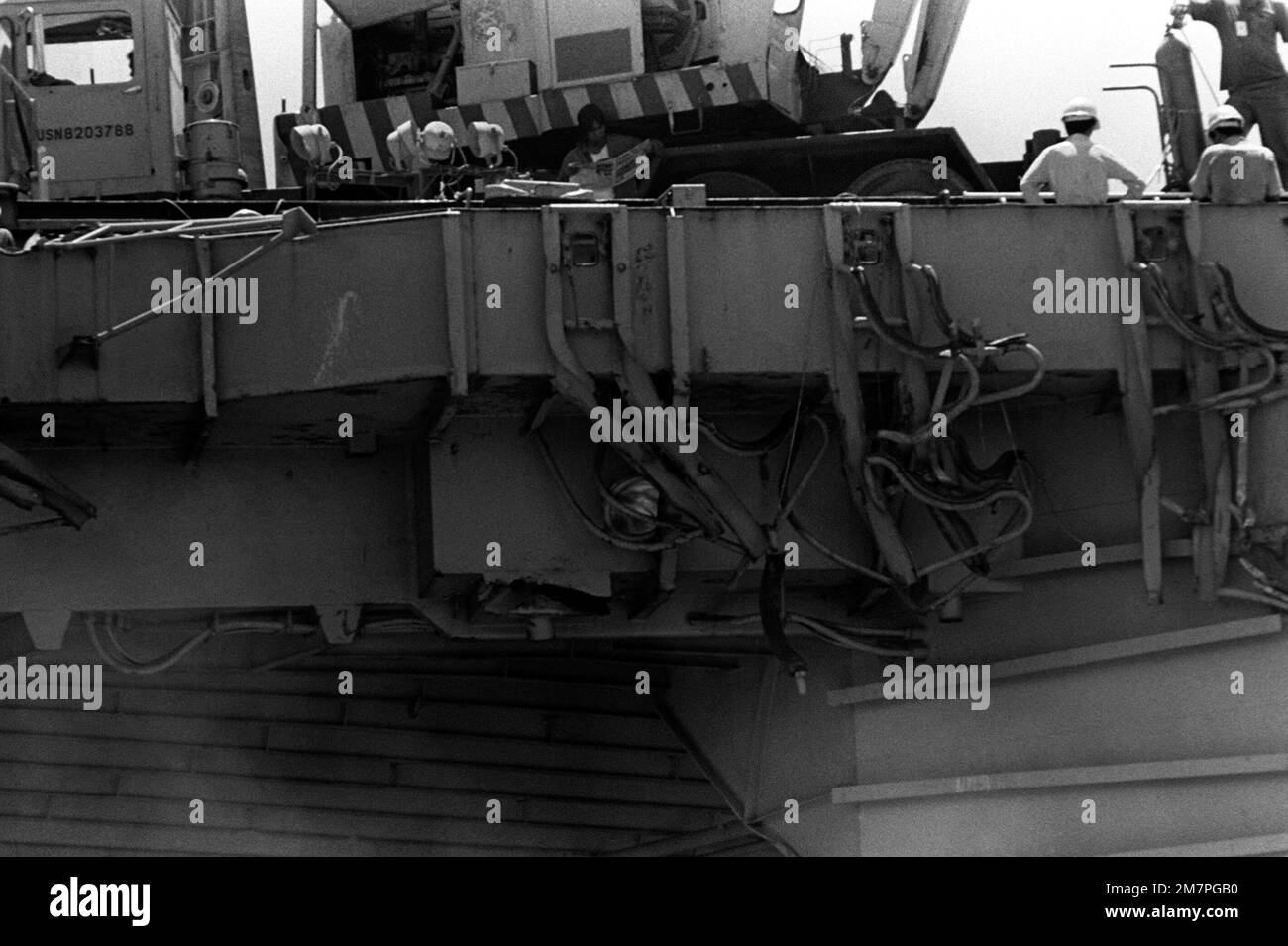 A view of damage caused to the port side of the aircraft carrier USS ...