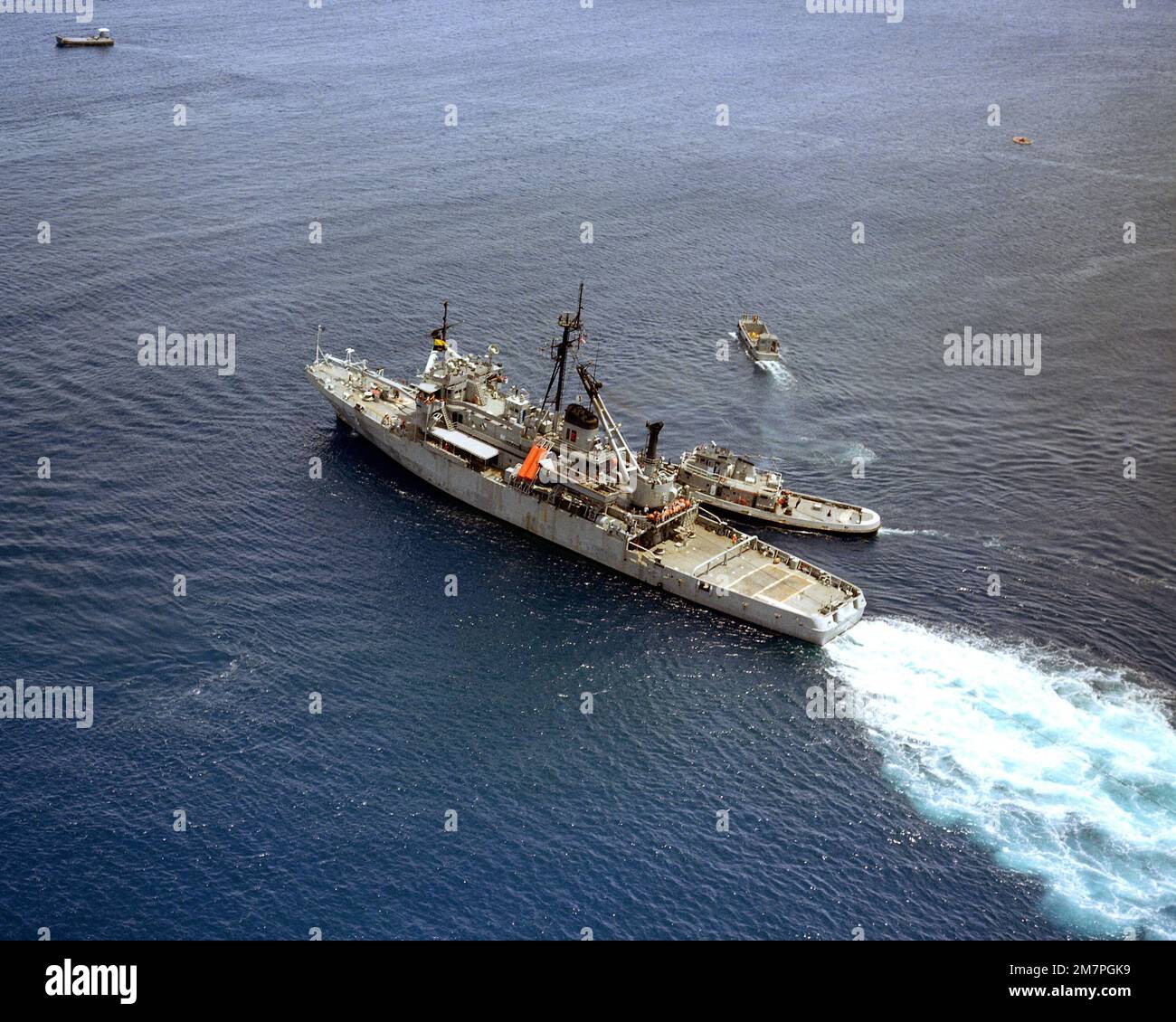 A harbor tug positions the salvage and rescue ship USS BRUNSWICK (ATS 3 ...