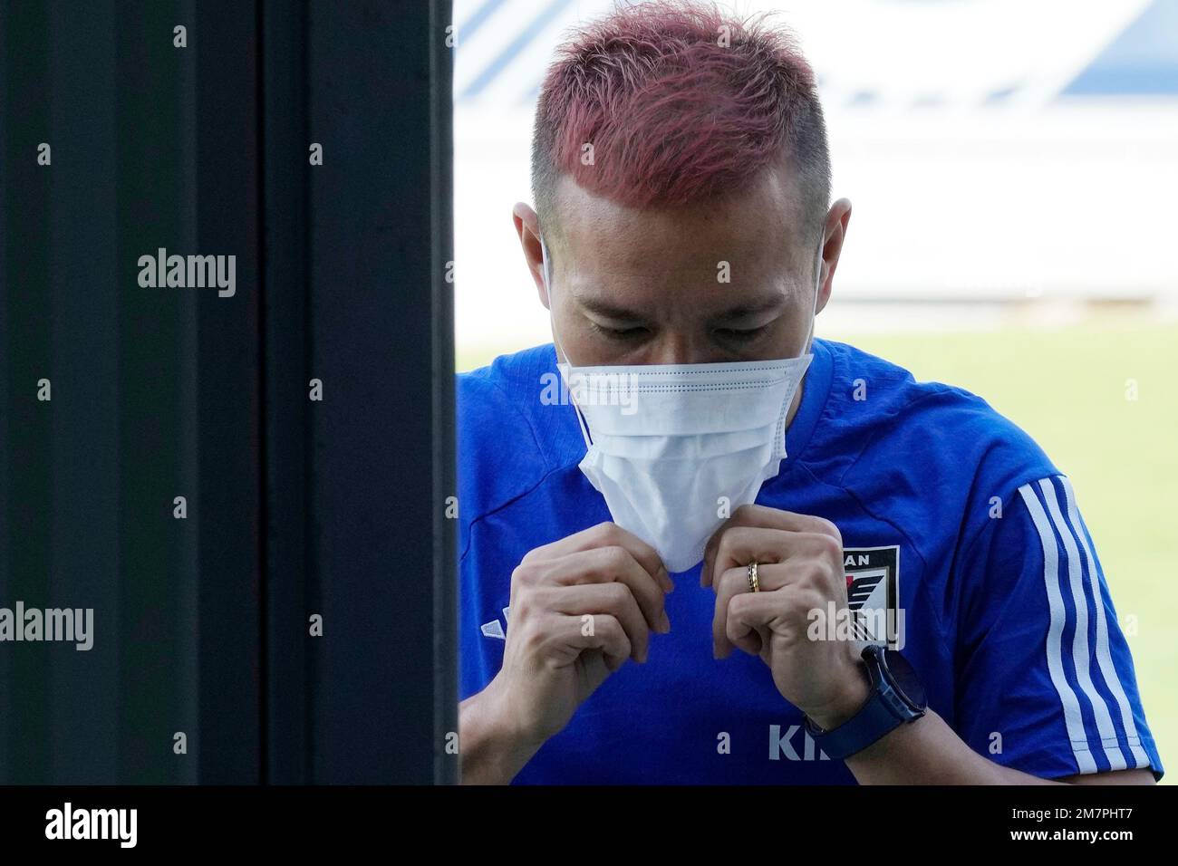 Japan's Yuto Nagatomo adjusts his protective mask as he walks to speak ...