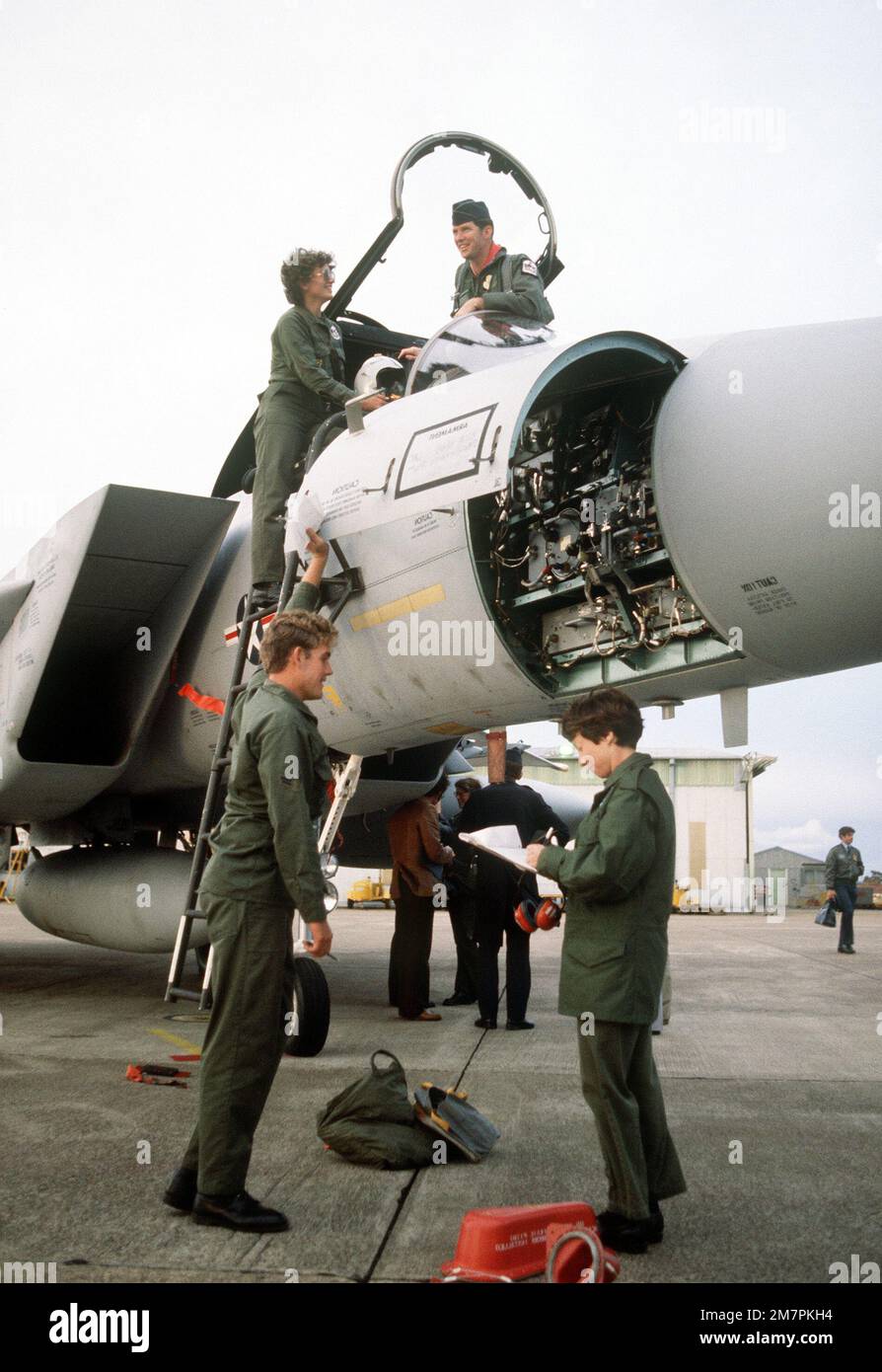 A pilot climbs into an F-15 Eagle aircraft for a flight. The pilot is ...