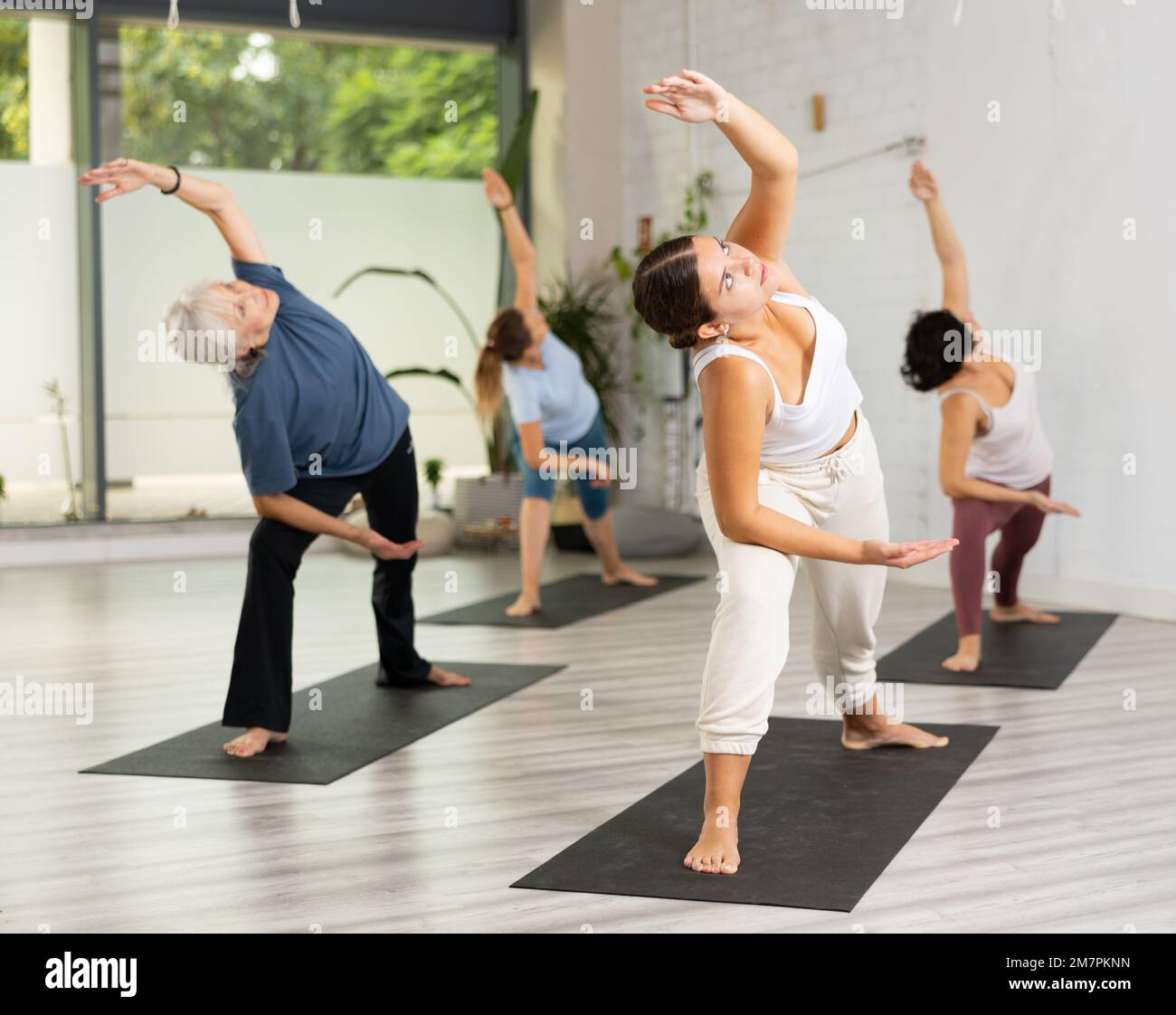 Active young female practicing Revolved Side Angle Pose Parivrtta ...