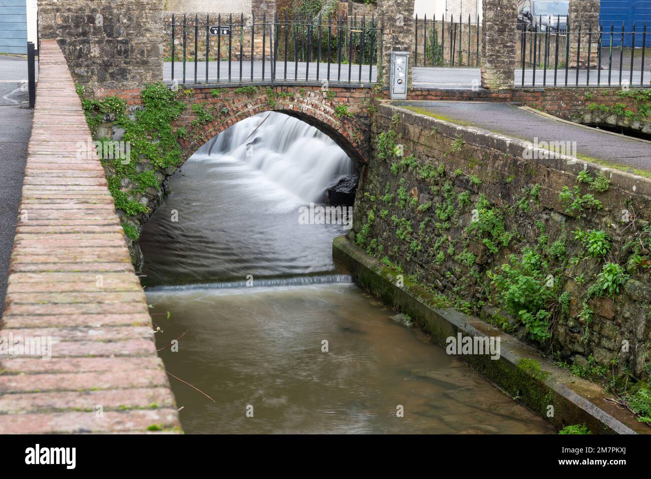 Long exposure of a watefall flowing under a bridge on the River Lim ...