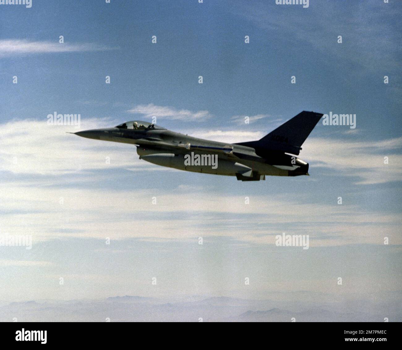 An air-to-air left side view of an F-16A Fighting Falcon aircraft with ...