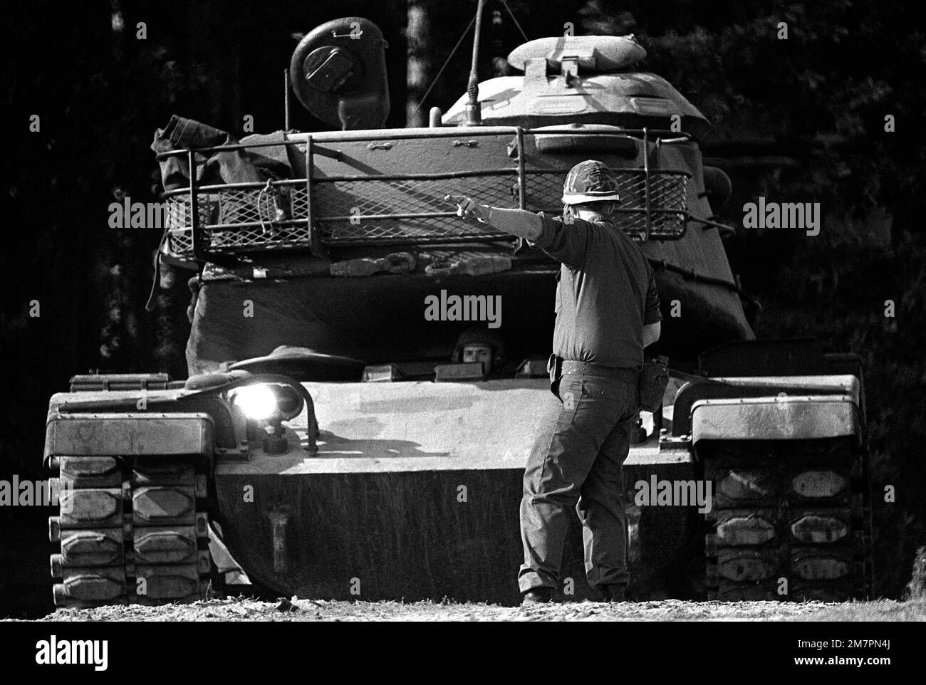 An Army tank commander directs a tank driver during Exercise Reforger ...