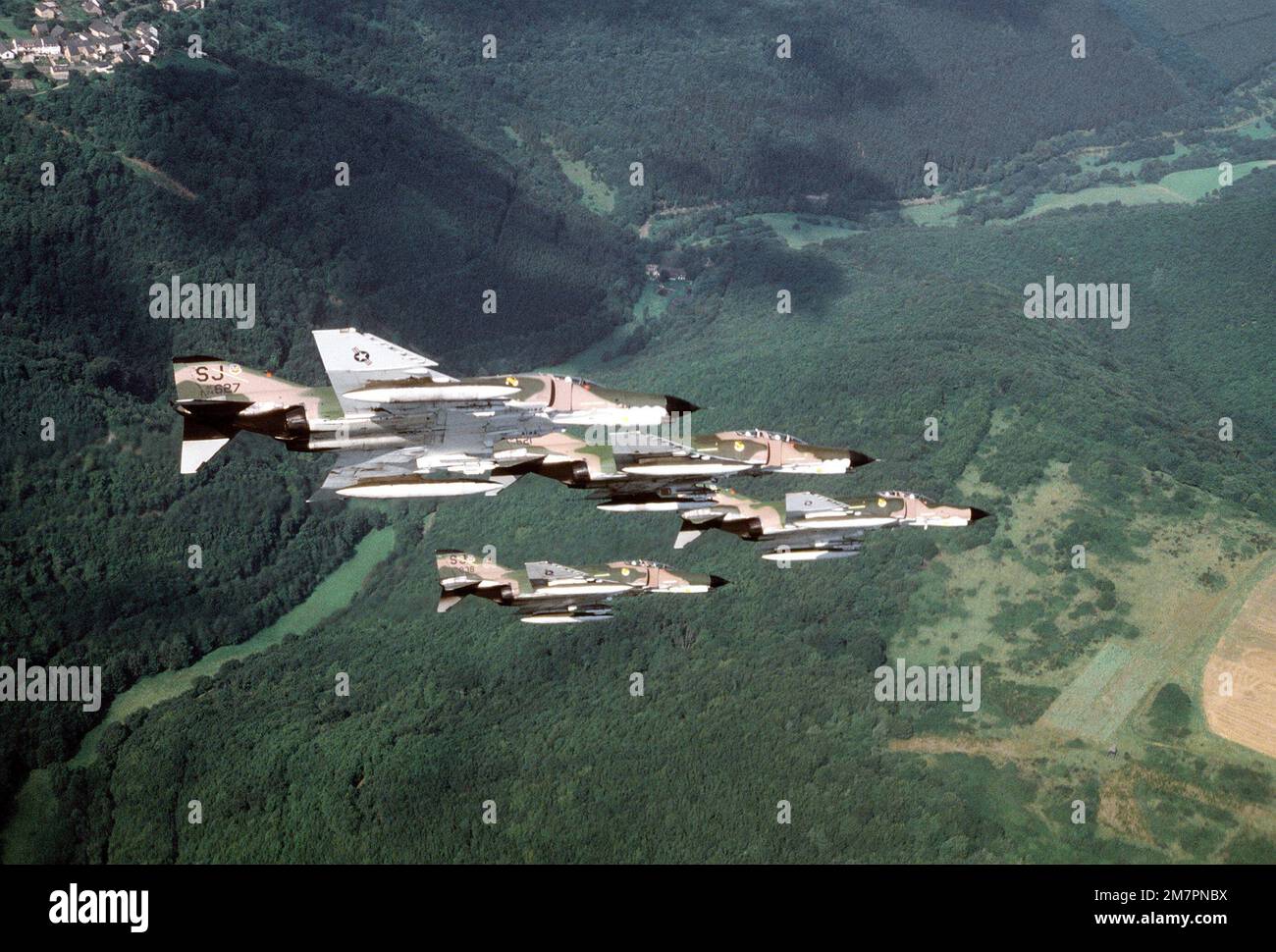 A right side view of four F-4E Phantom II aircraft banking to the left ...