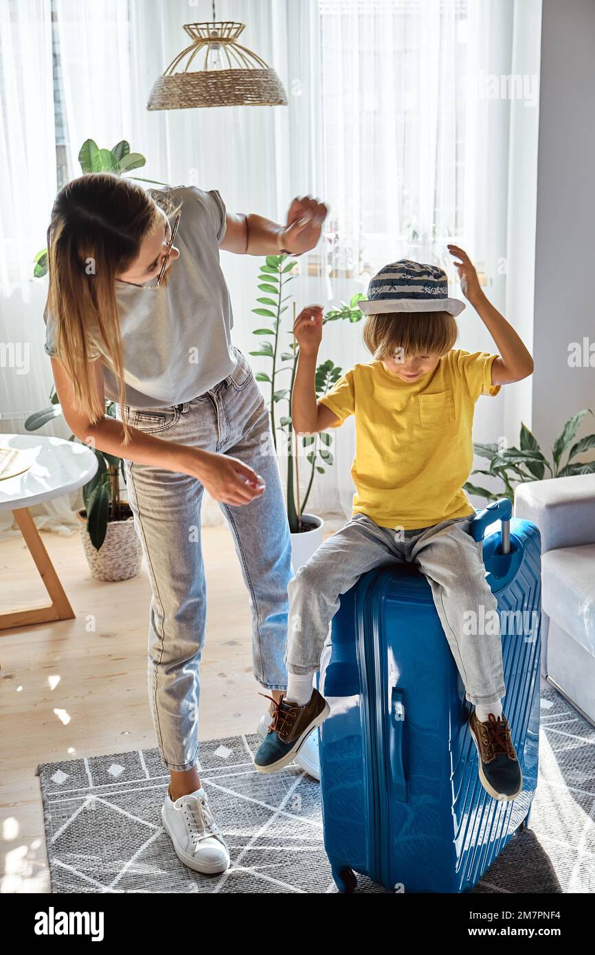 Family mother and child together packed a suitcase and have fun going ...