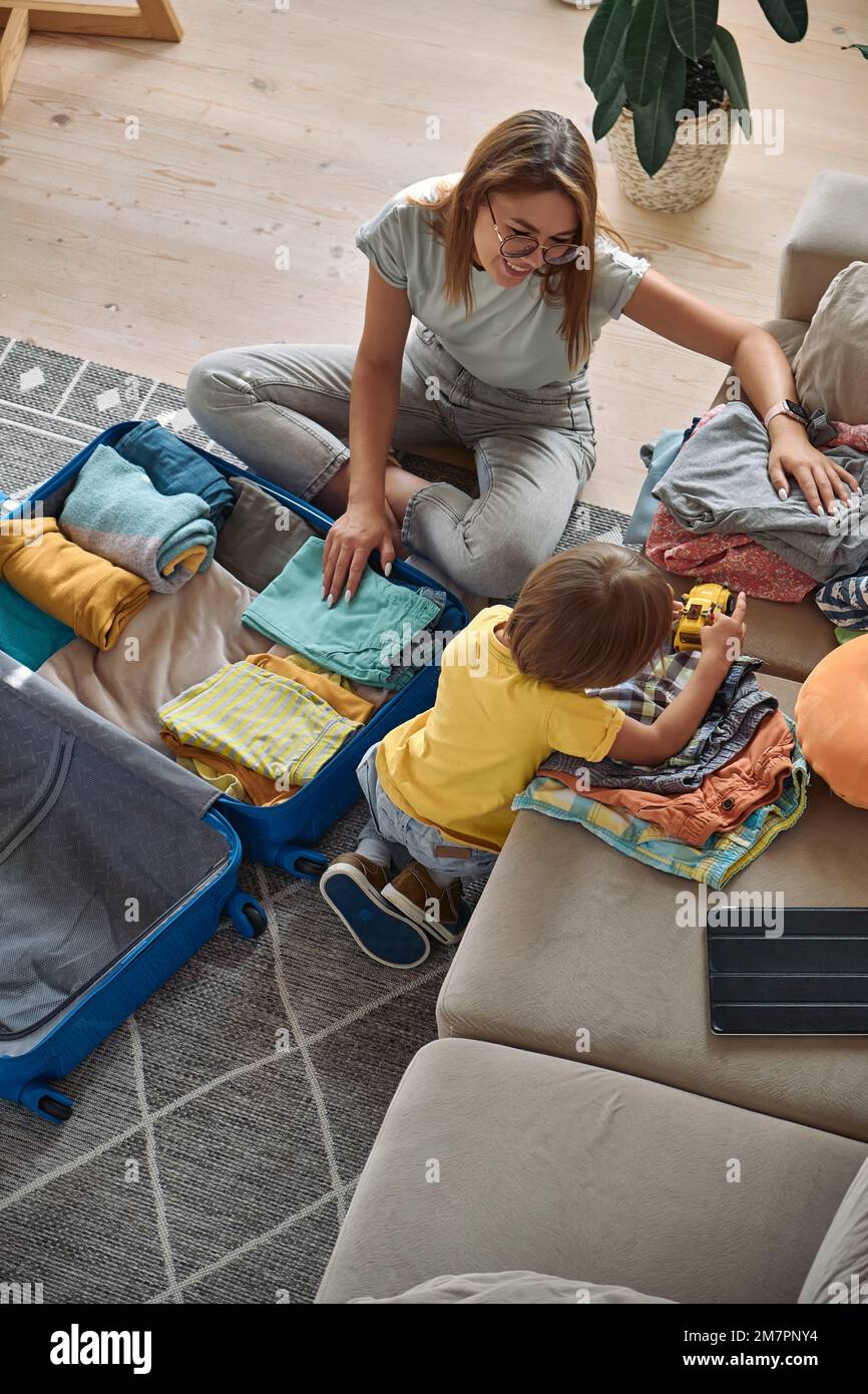 Family going on a trip or vacation, mother packing a suitcase, child ...
