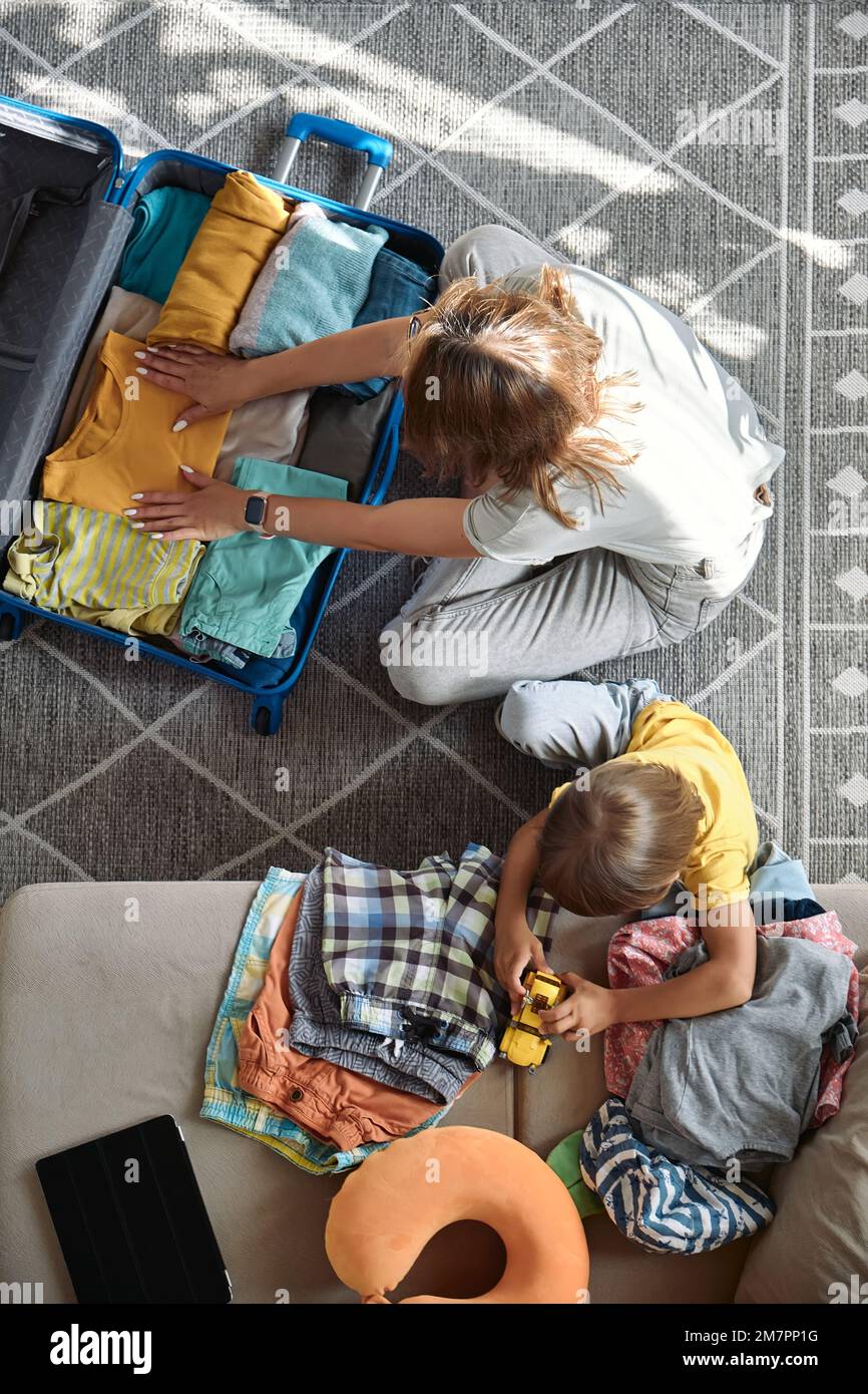 Family going on a trip or vacation, mother packing a suitcase, child ...