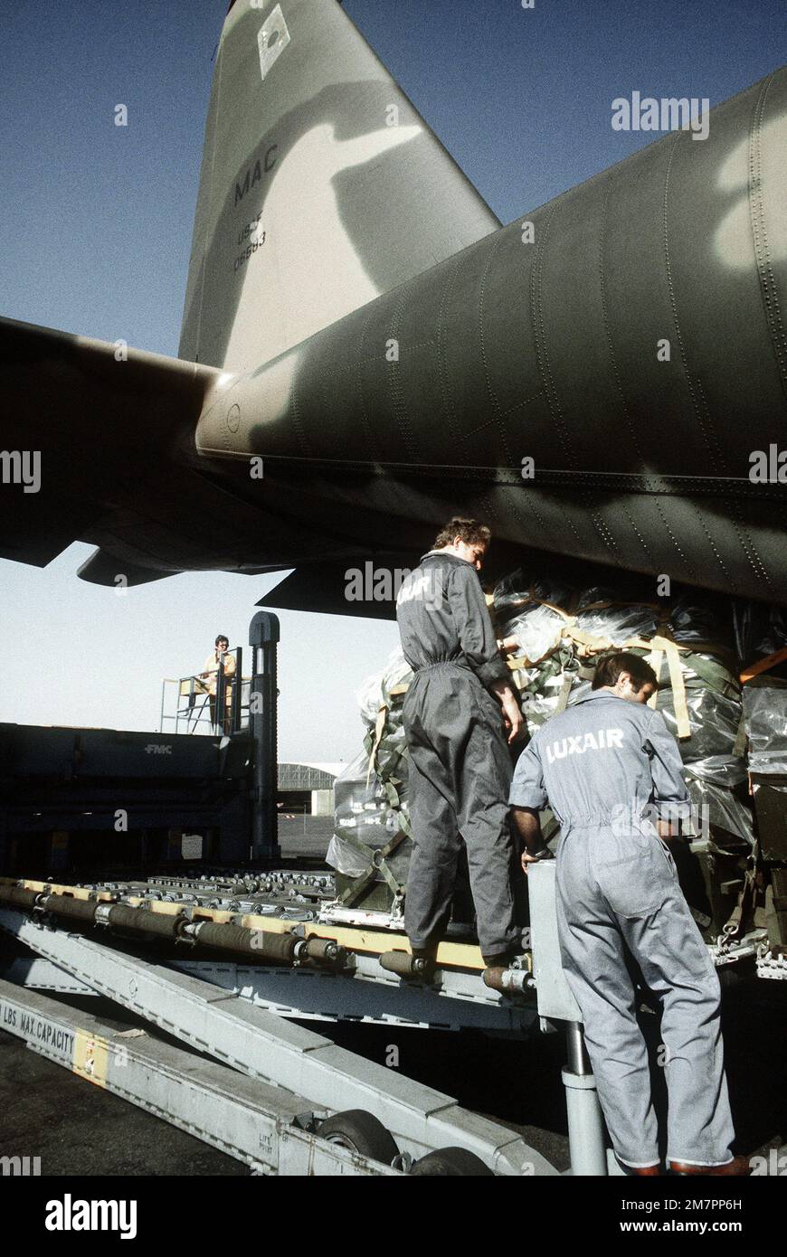 Natives help unload cargo from a U.S. Air Force C-130 Hercules aircraft ...