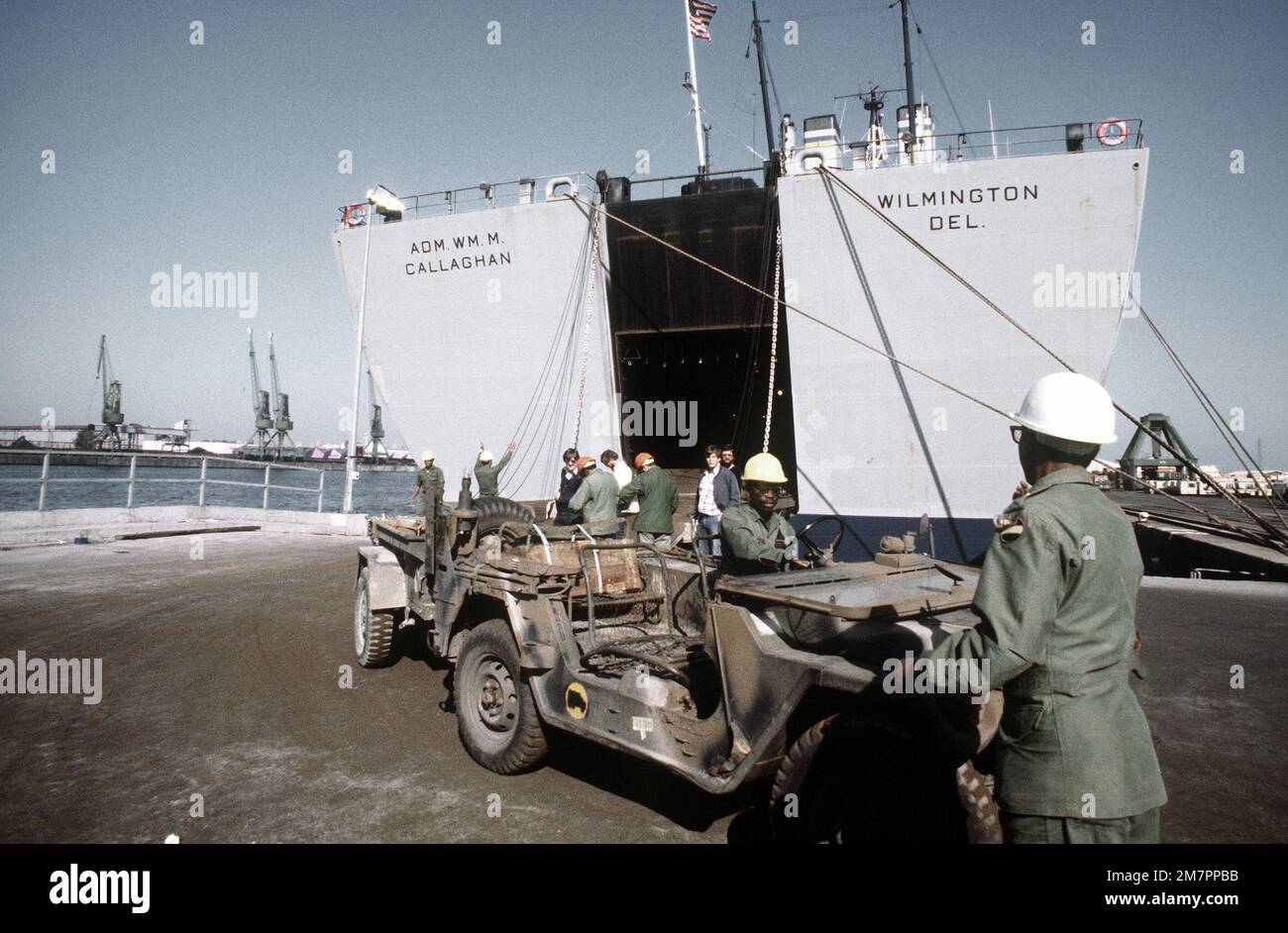 A jeep, towing a trailer, is being unloaded from the GTS ADM WILLIAM M ...