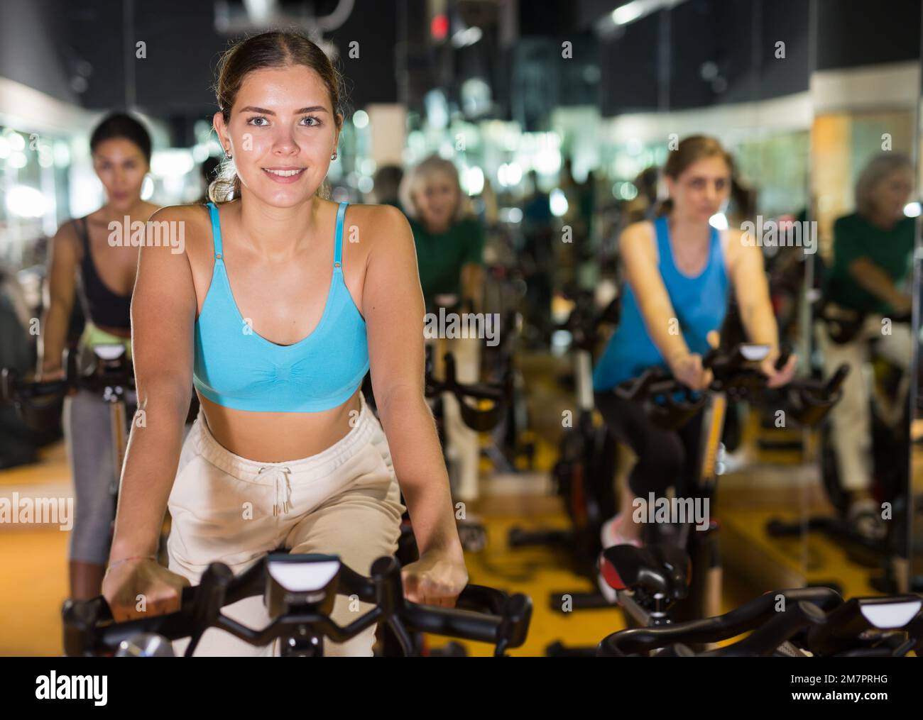 Young girl on training using bike in gym Stock Photo - Alamy