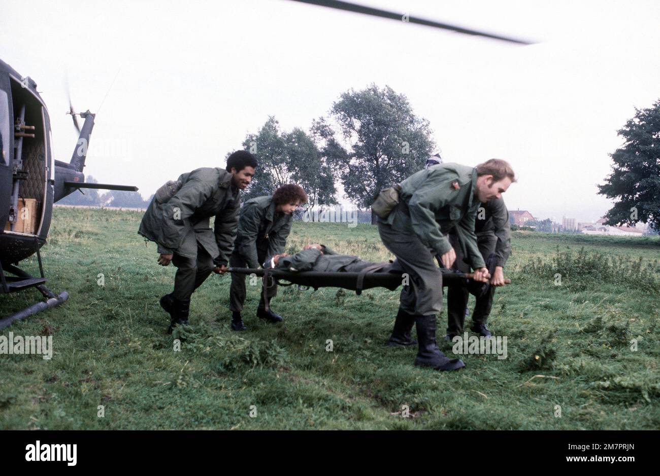 Medical airmen carry a "wounded soldier" to a UN-1N Iroquois helicopter ...