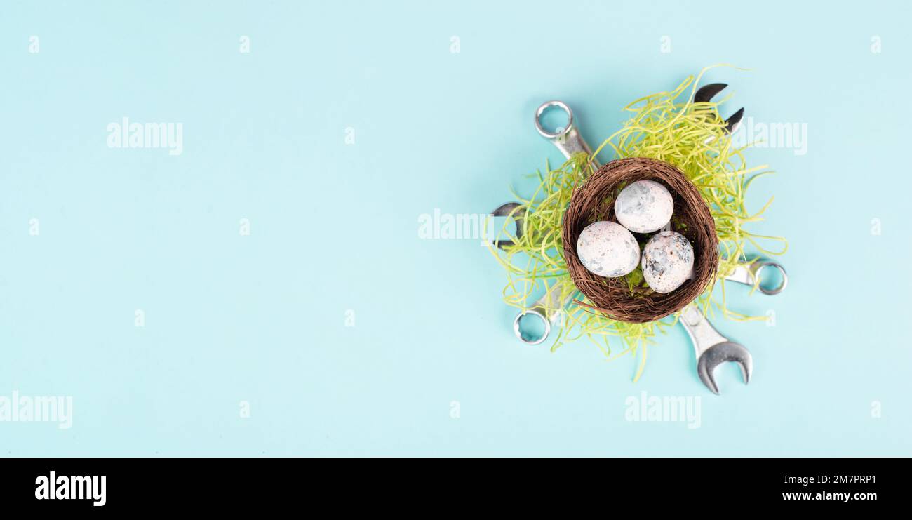Easter eggs in a bird nest, wrenches and green grass, holiday greeting ...