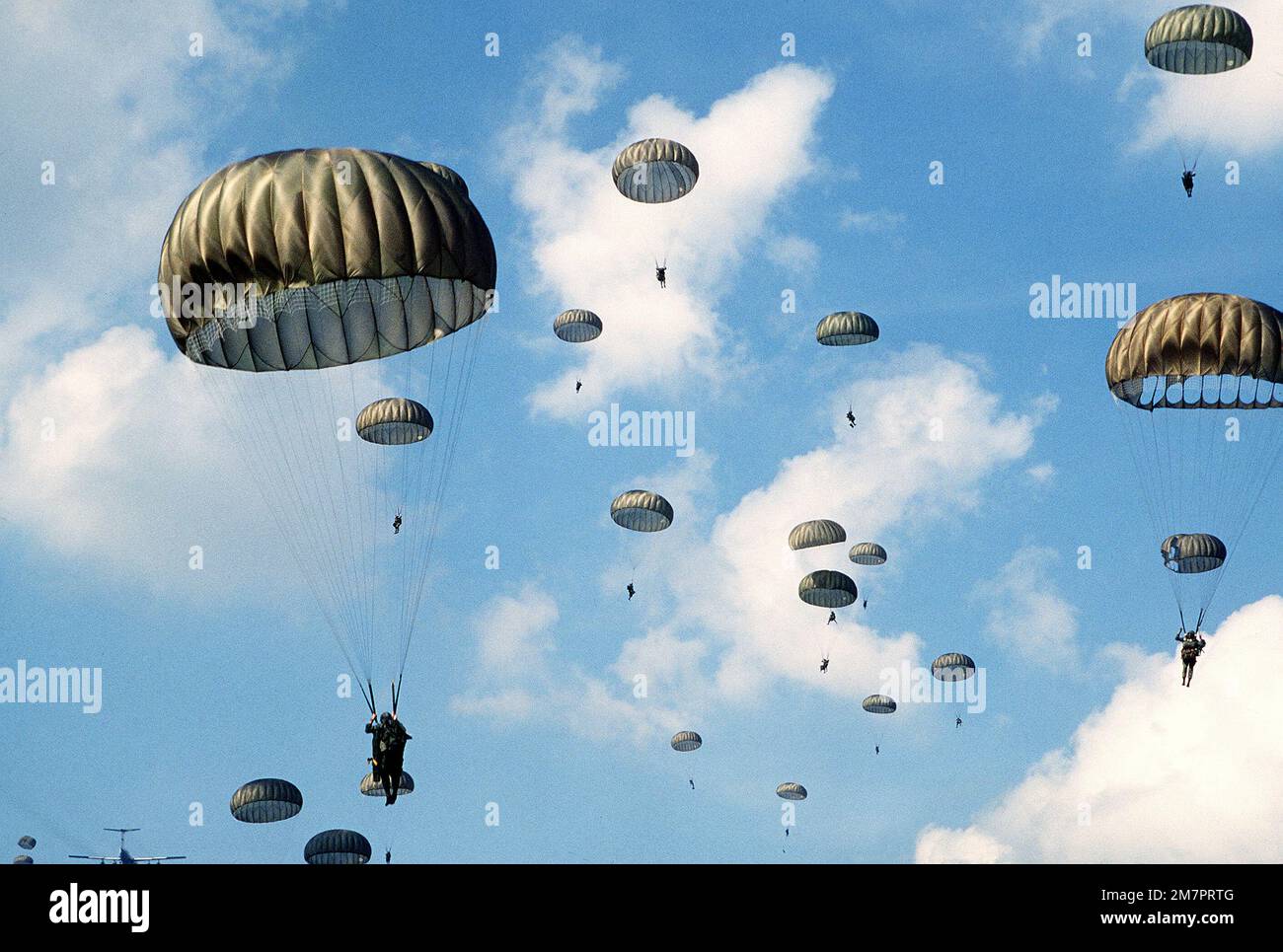 Members of the 82nd Airborne Division parachute from a C-141B ...