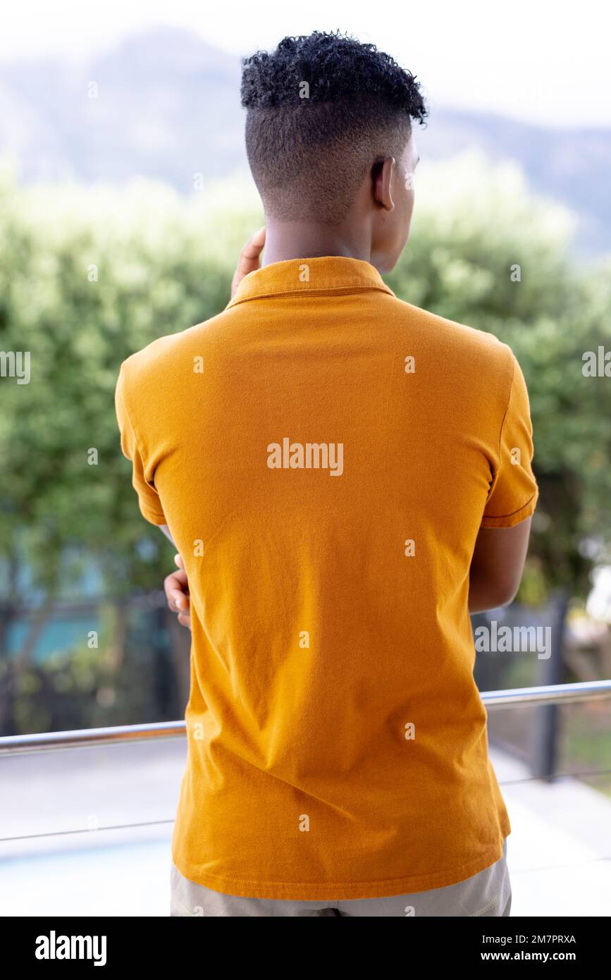 Image of rear view of biracial man in orange short sleeve polo t shirt ...