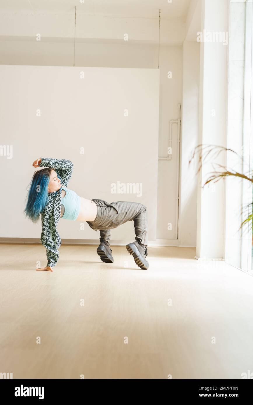 Vertical image of caucasian female hip hop dancer practicing at dance ...