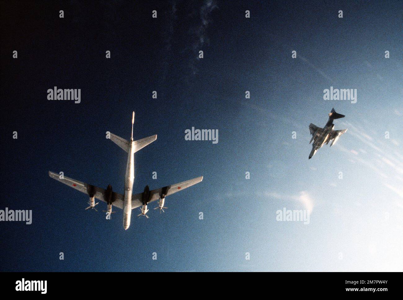 AN air-to-air underside view of a Soviet Tu-95 Bear aircraft, left ...