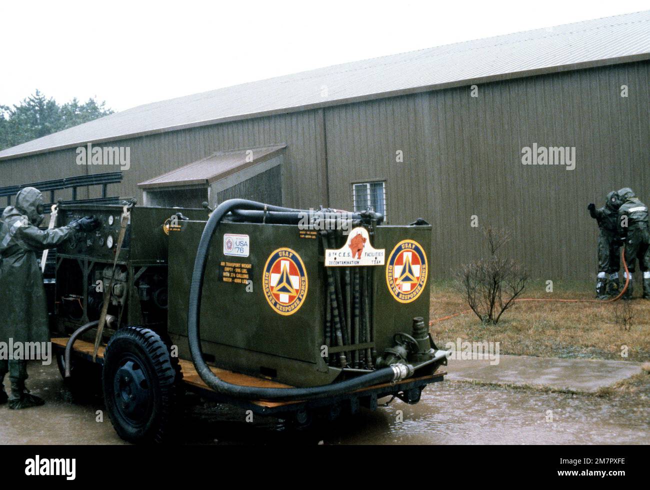 Members of the Disaster Response Force decontaminate one of the base ...