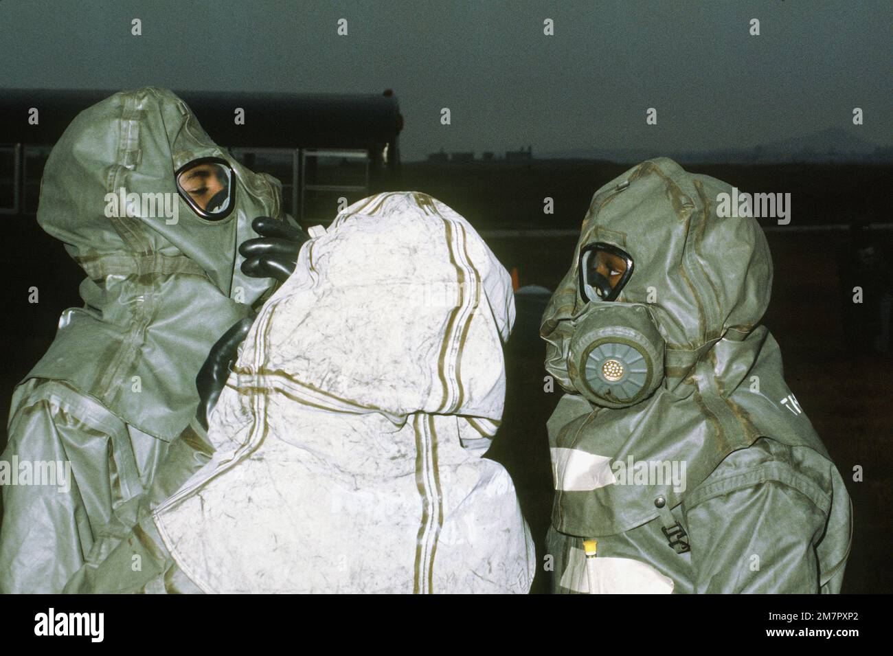 A decontamination team wearing chemical warfare gear takes part in a ...