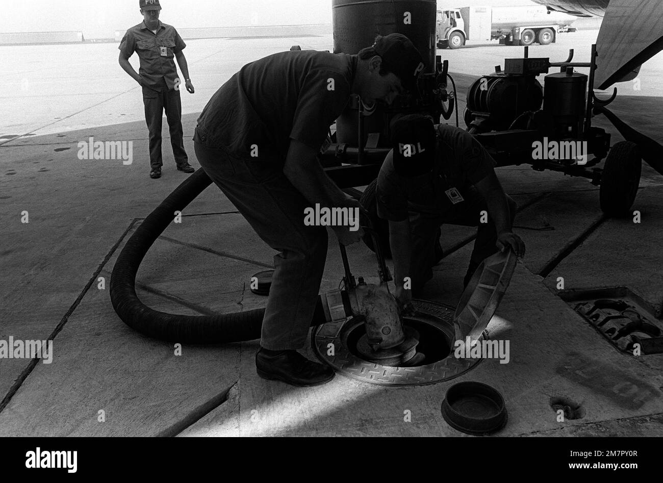 A1C Bill Adams and SSGT Randall Simeona hook up an MH-2A hose cart to ...