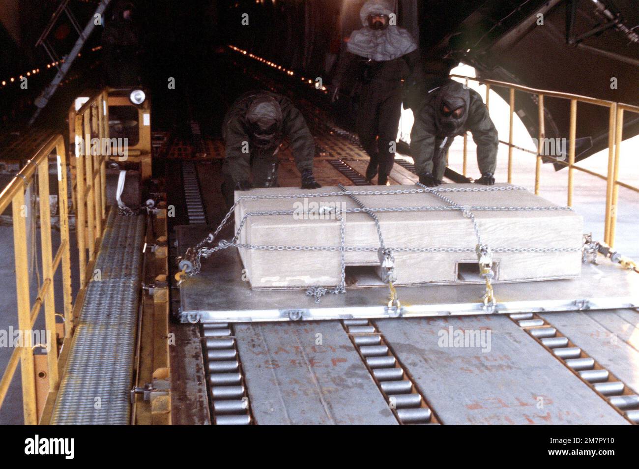 Dressed in chemical warfare gear, members of the 436th Military Airlift ...