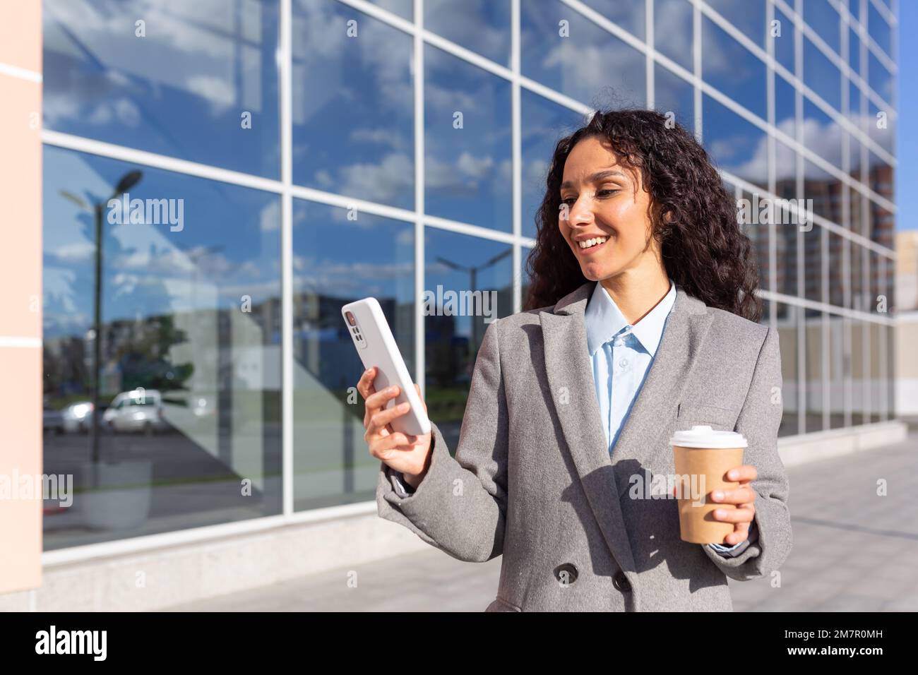 Beautiful and successful hispanic business woman using smartphone from ...